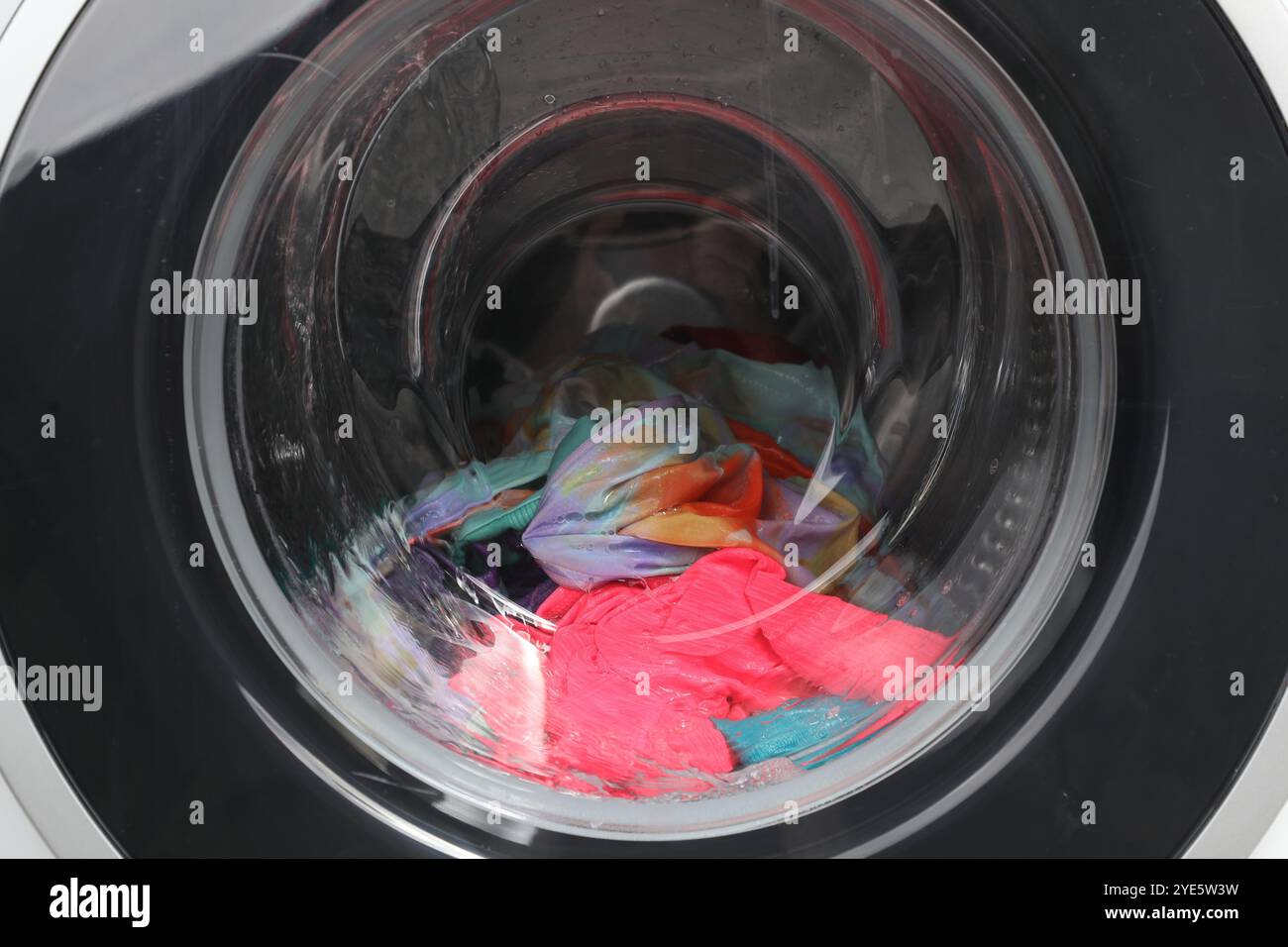 Washing machine with laundry as background, closeup Stock Photo - Alamy