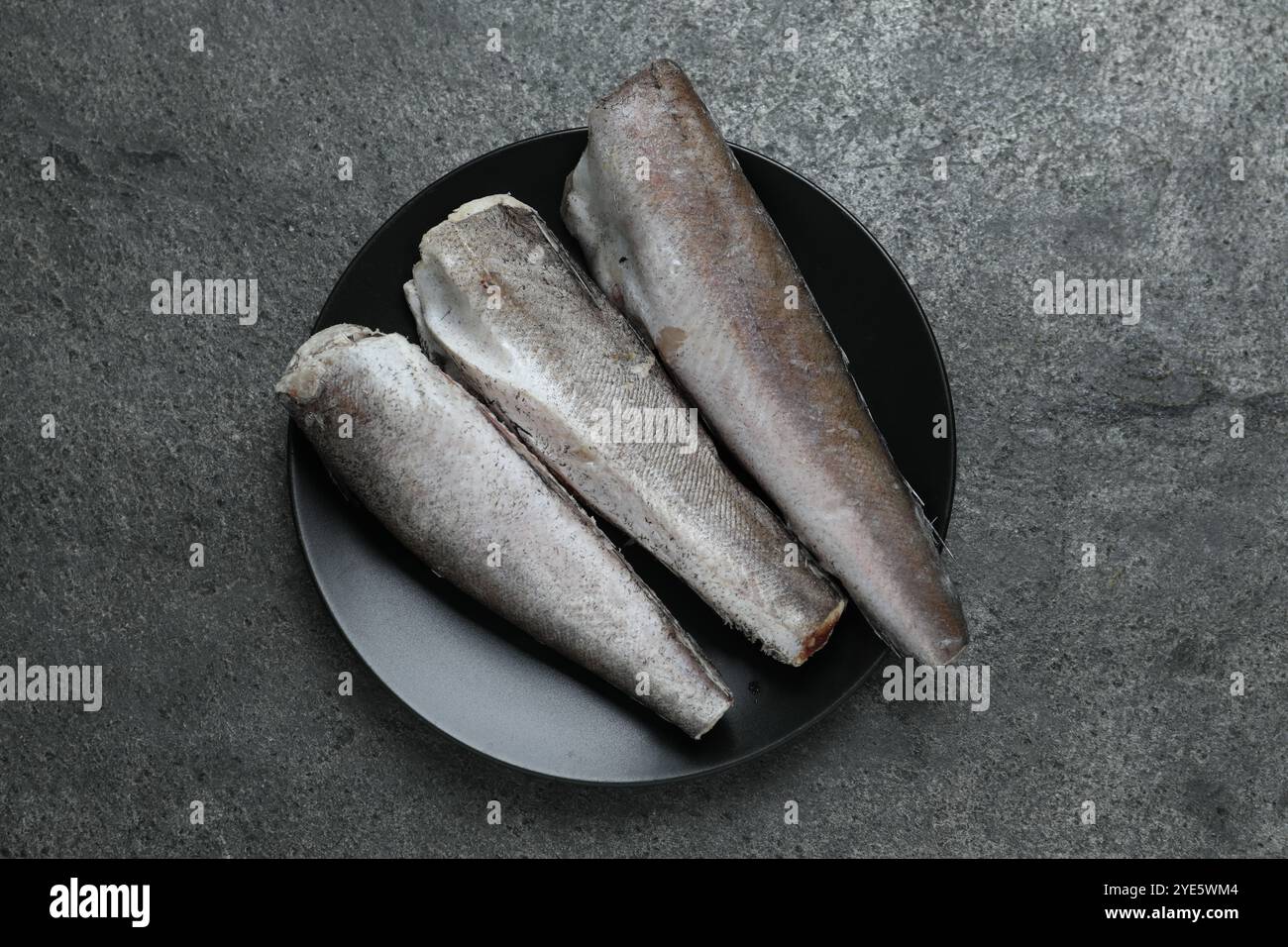Frozen hake fishes on grey table, top view Stock Photo - Alamy