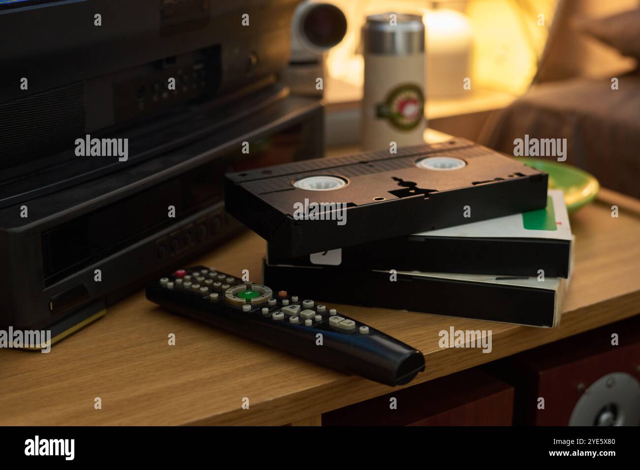 Close-up of several vintage VHS tapes stacked near remote control on ...