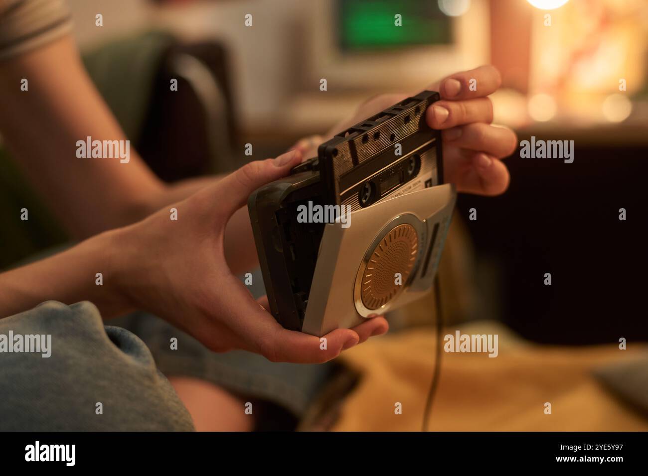 Hands handling vintage cassette tape player with focus on the device ...