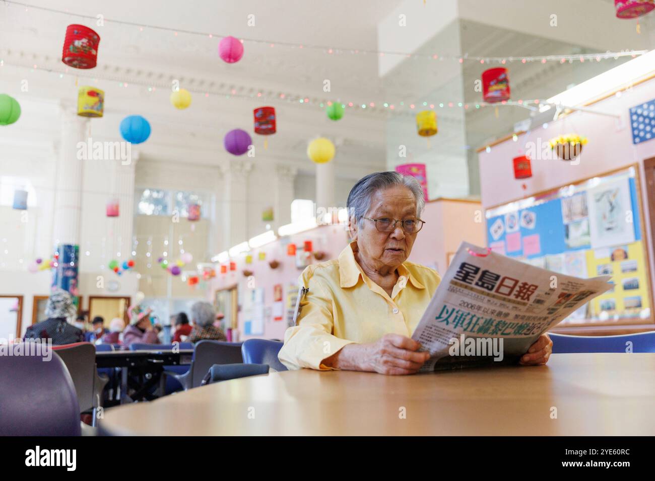 Fengling He reads the Sing Tao Daily newspaper at adult daycare Hong ...