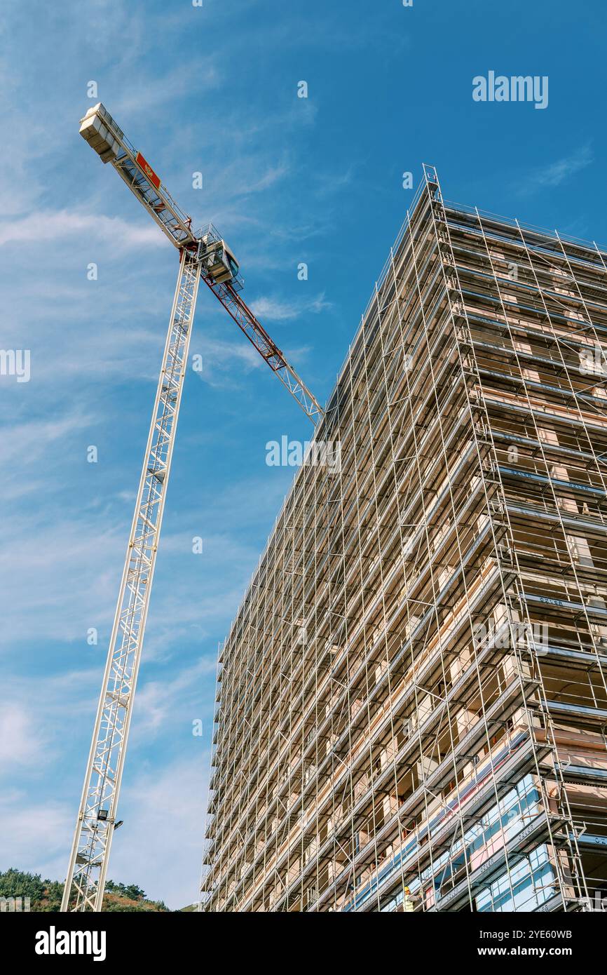 Large tower crane builds a high-rise building against a blue sky Stock ...