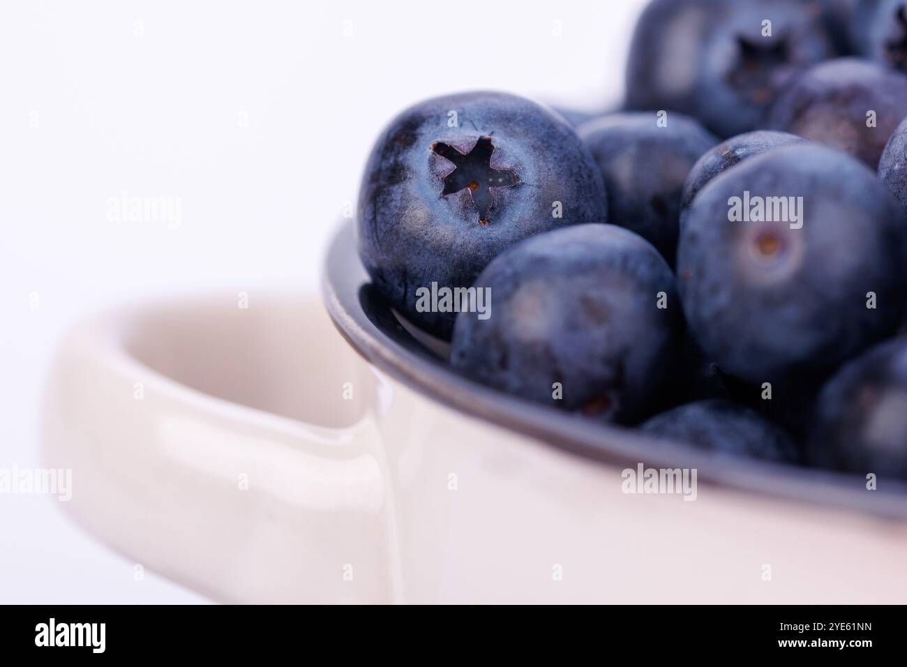 A small ceramic pot overflowing with blueberries, captured in detail on ...