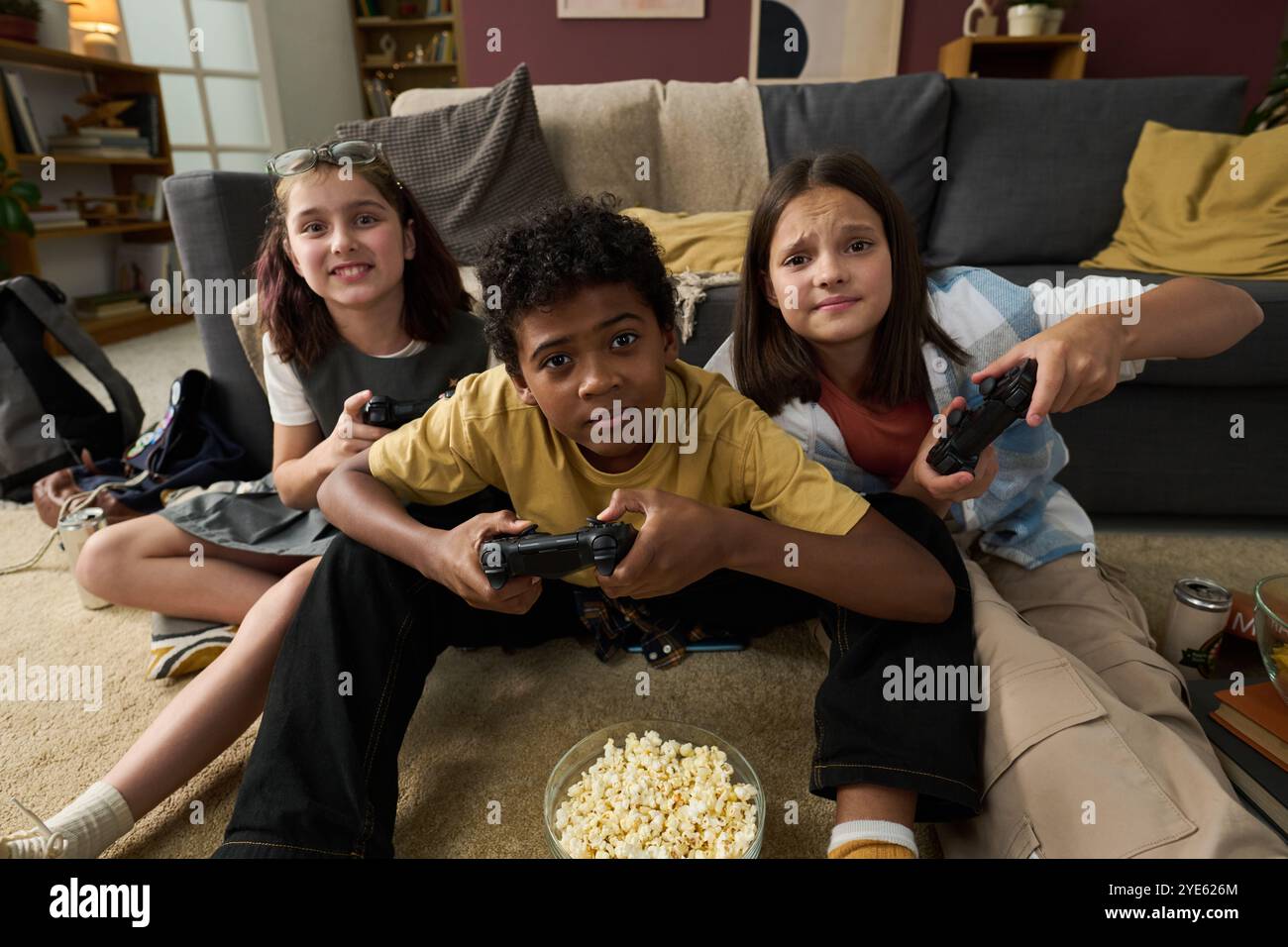 Diverse group of children sitting on floor in living room, playing ...