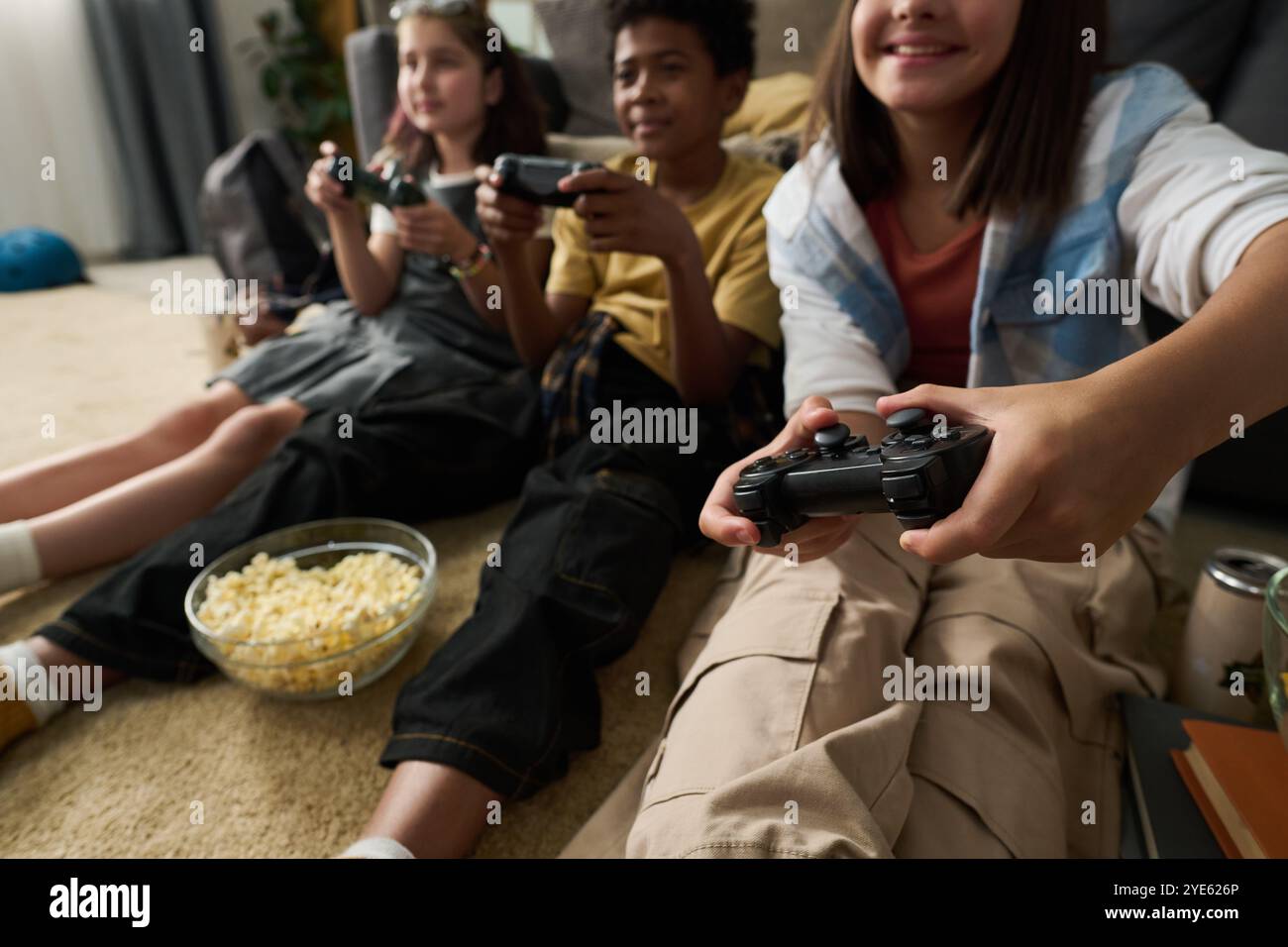Group of friends sitting together in living room, immersed in playing ...