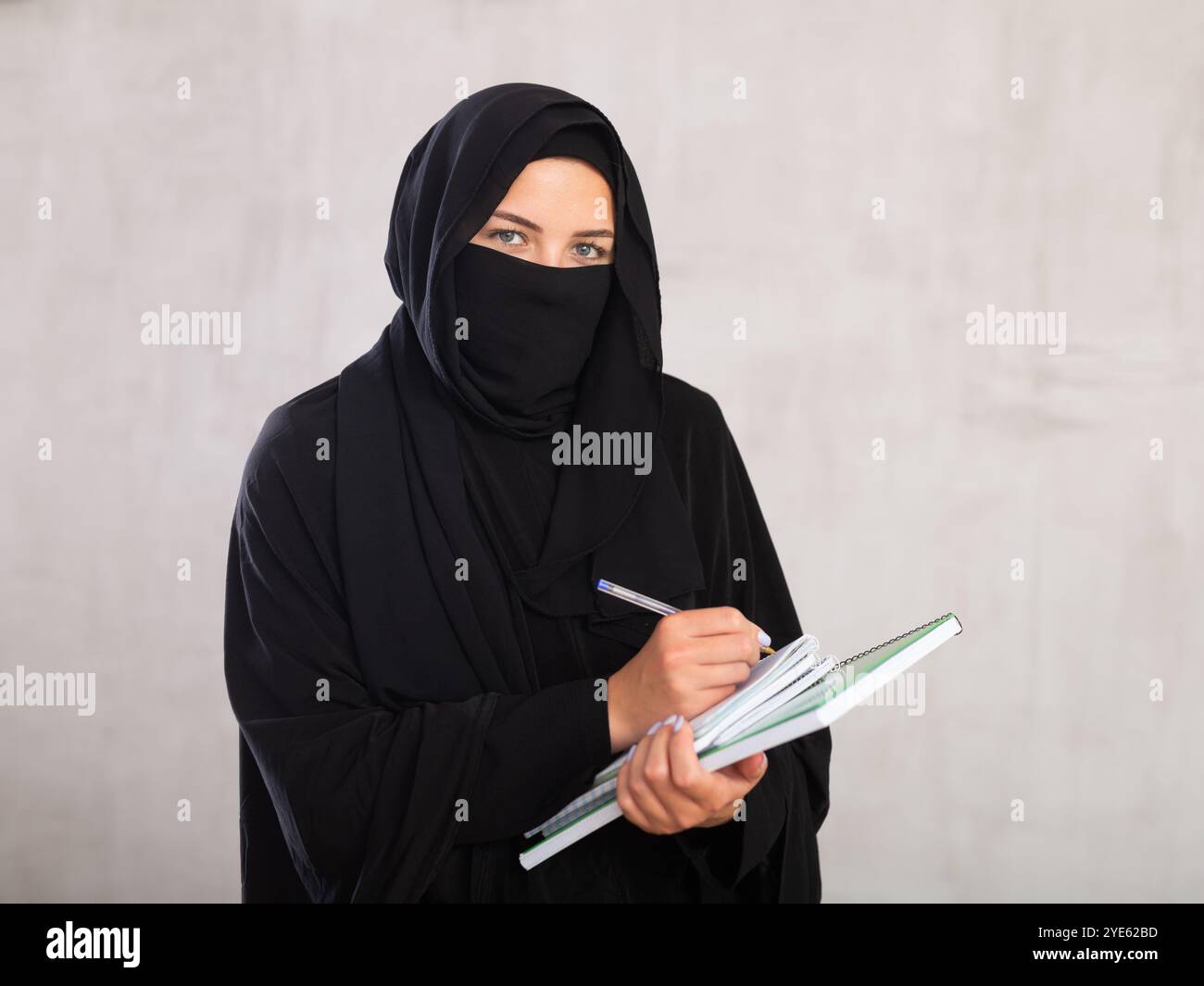 Young student woman dressed in traditional islamic clothes with her ...
