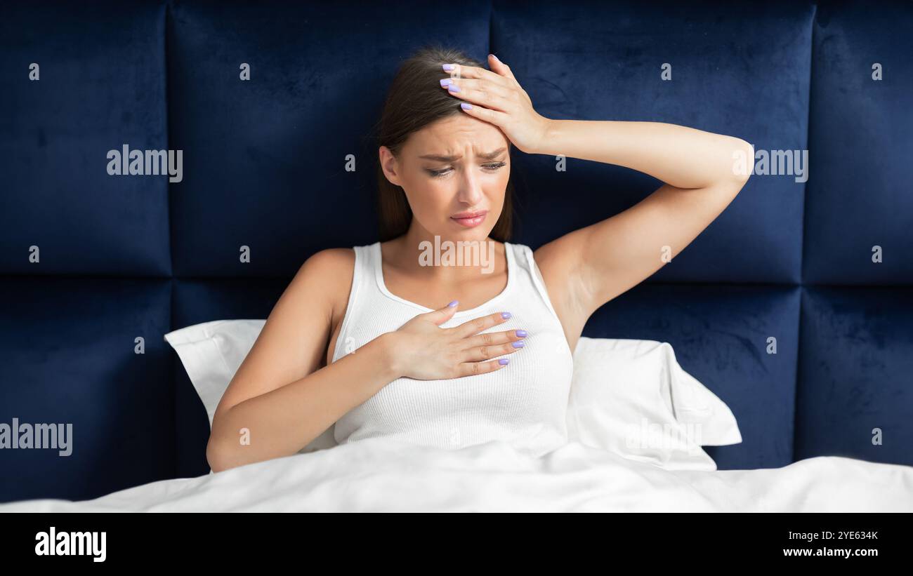 Woman Having Fever And Breathing Difficulty Sitting In Bed Indoors ...