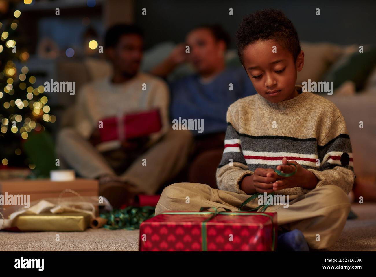 Front view portrait of cute African American boy opening Christmas ...