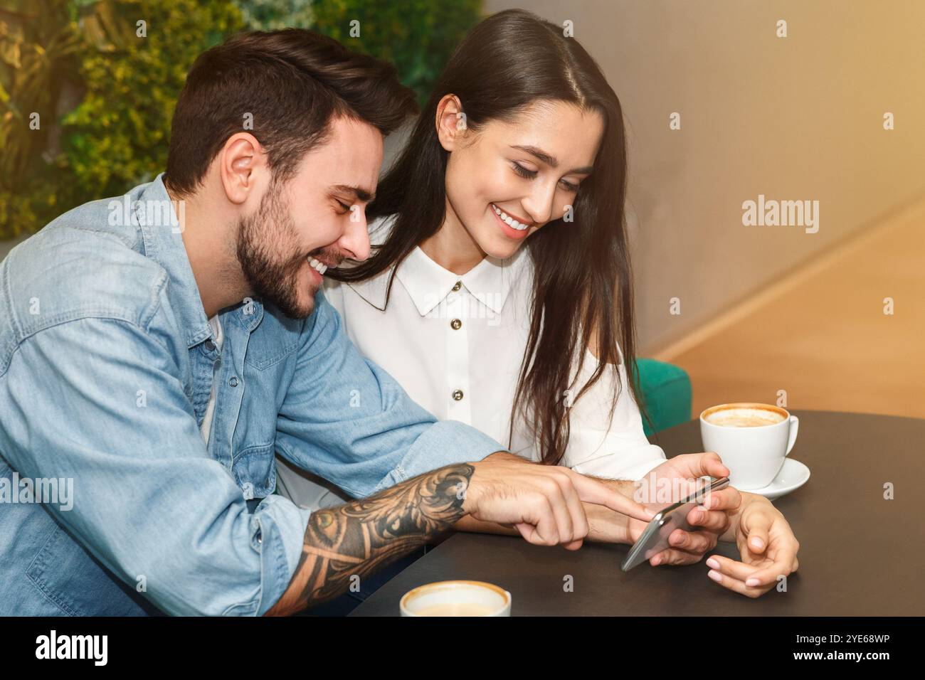 Boyfriend And Girlfriend Using Phone During Date In Cafe Stock Photo ...