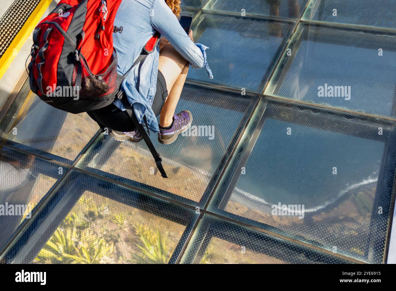Tourist standing on the transparent glass skywalk of the viewpoint of ...