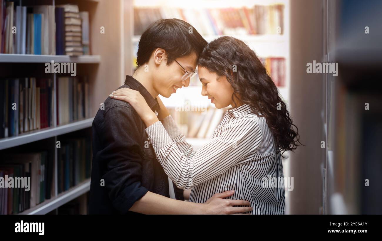 Two multicultural students hugging at modern library Stock Photo - Alamy
