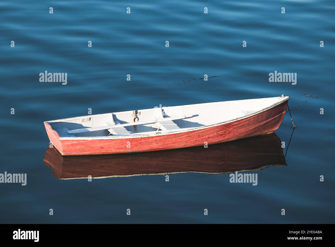 Red Row Boat Reflection in Blue Rippled Water Stock Photo - Alamy