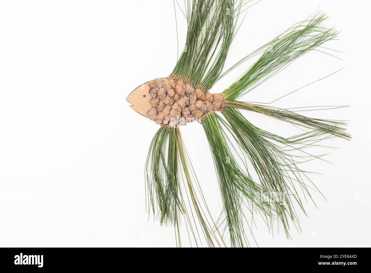 cardboard cut into the shape of a fish, with small pine cone scales ...