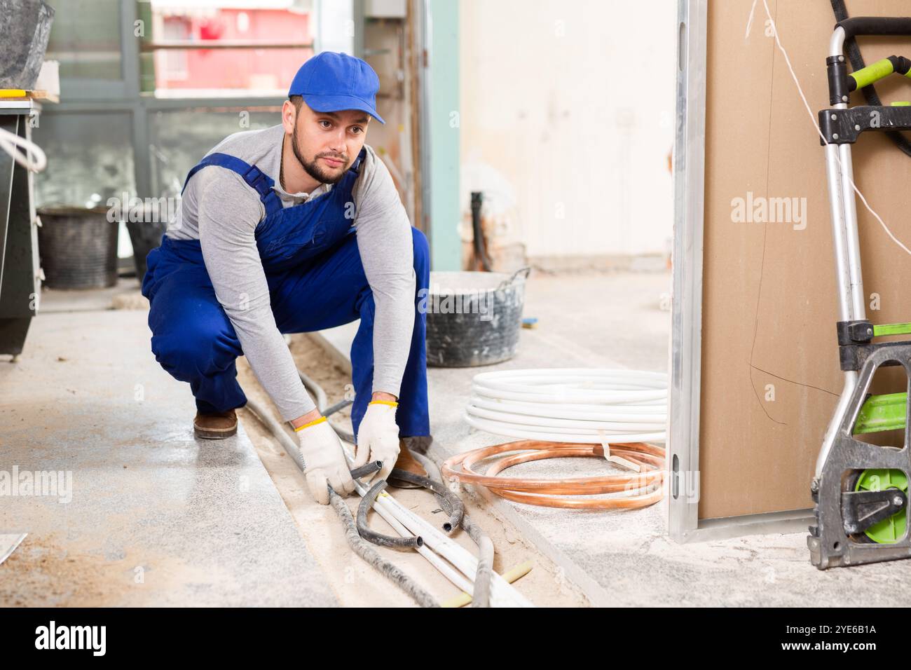 Man electrical installer laying cables through trench Stock Photo - Alamy