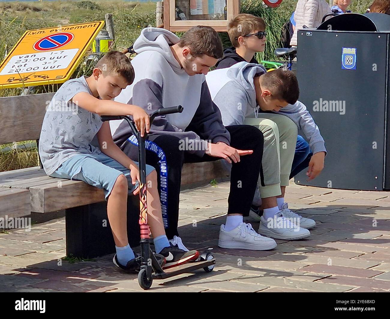 four brothers sitting bored on a bench, Netherlands Stock Photo - Alamy