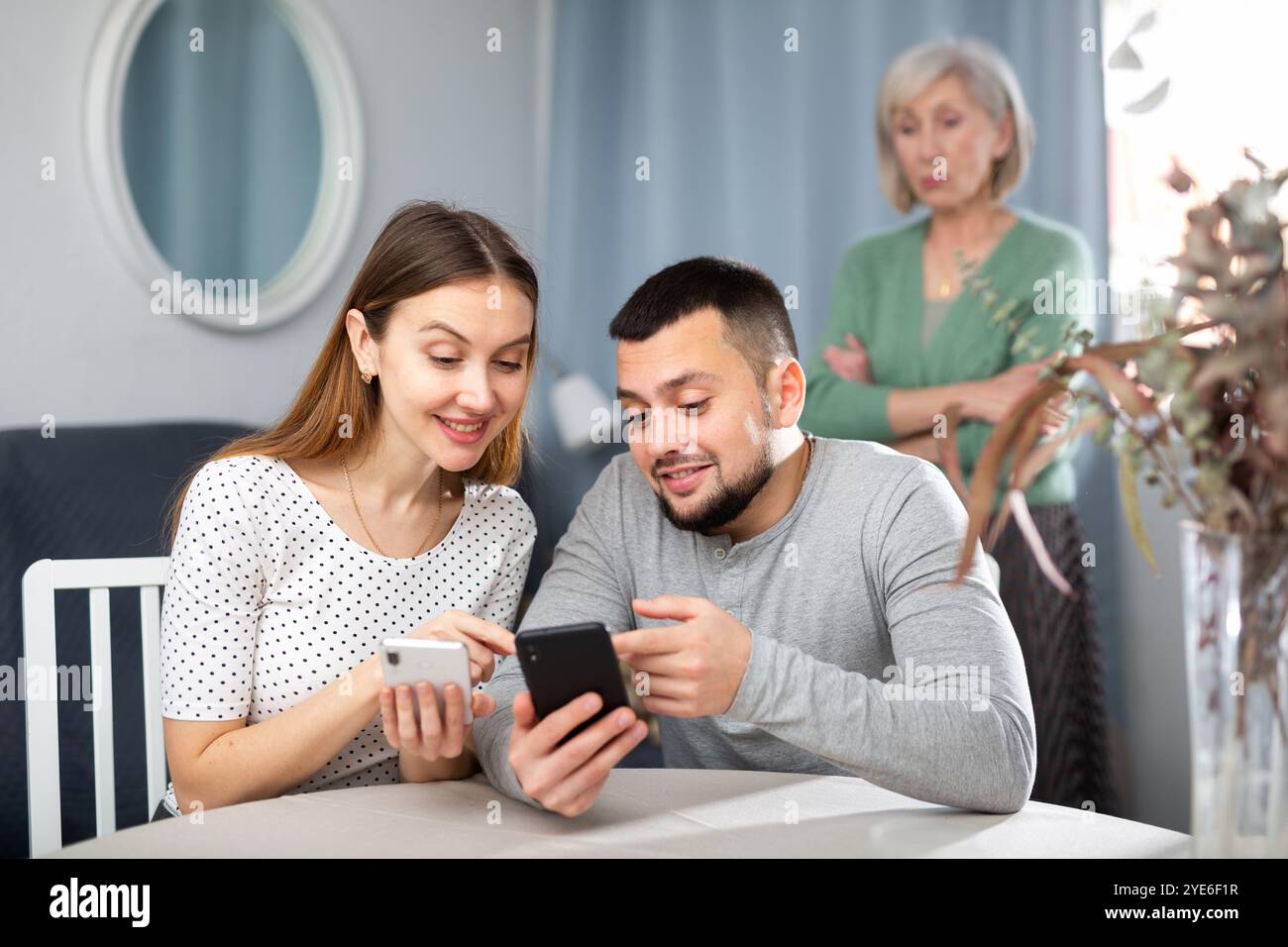 Couple ignoring arguing mature woman at home Stock Photo - Alamy