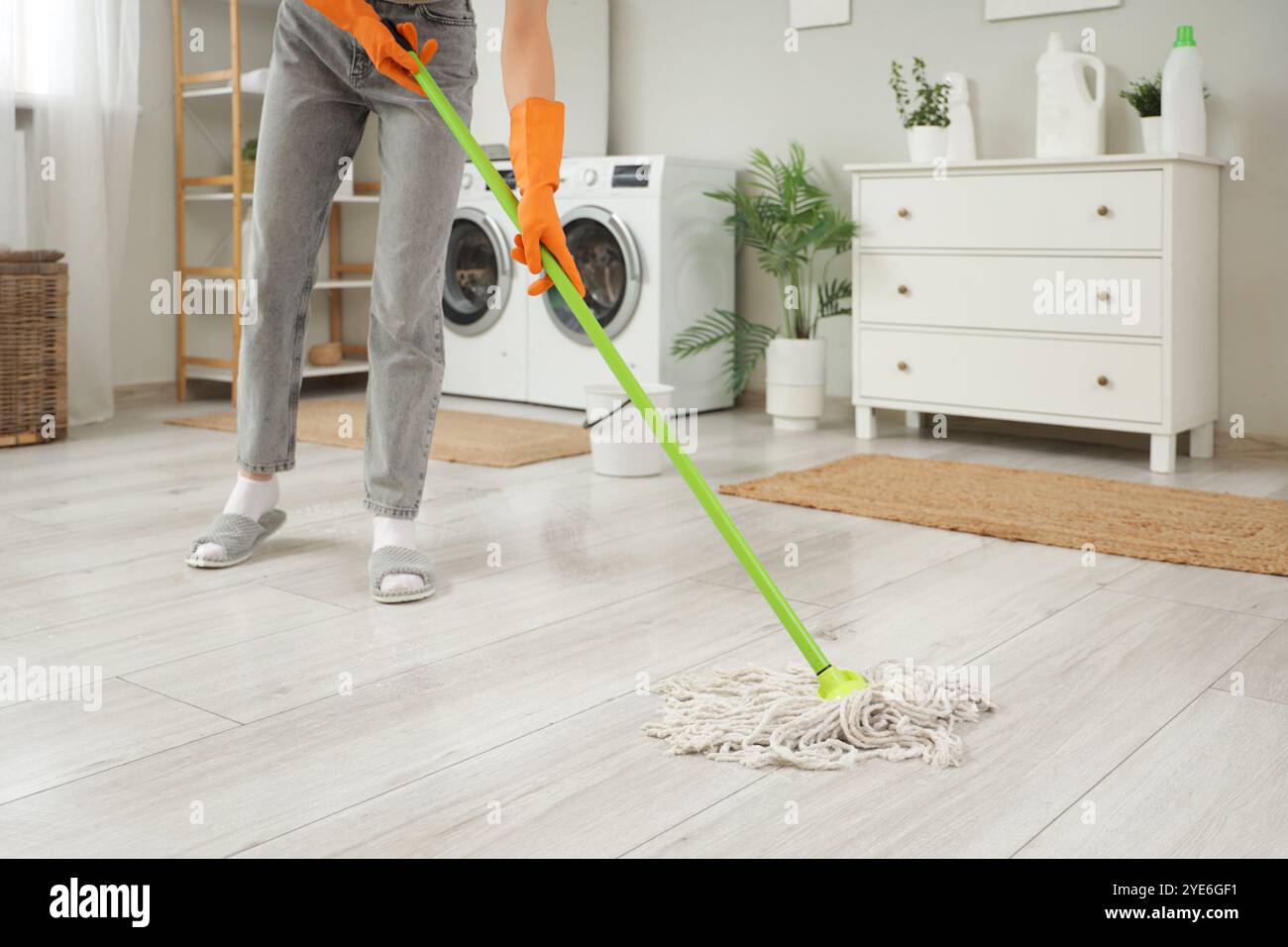 Woman mopping floor in laundry room Stock Photo - Alamy