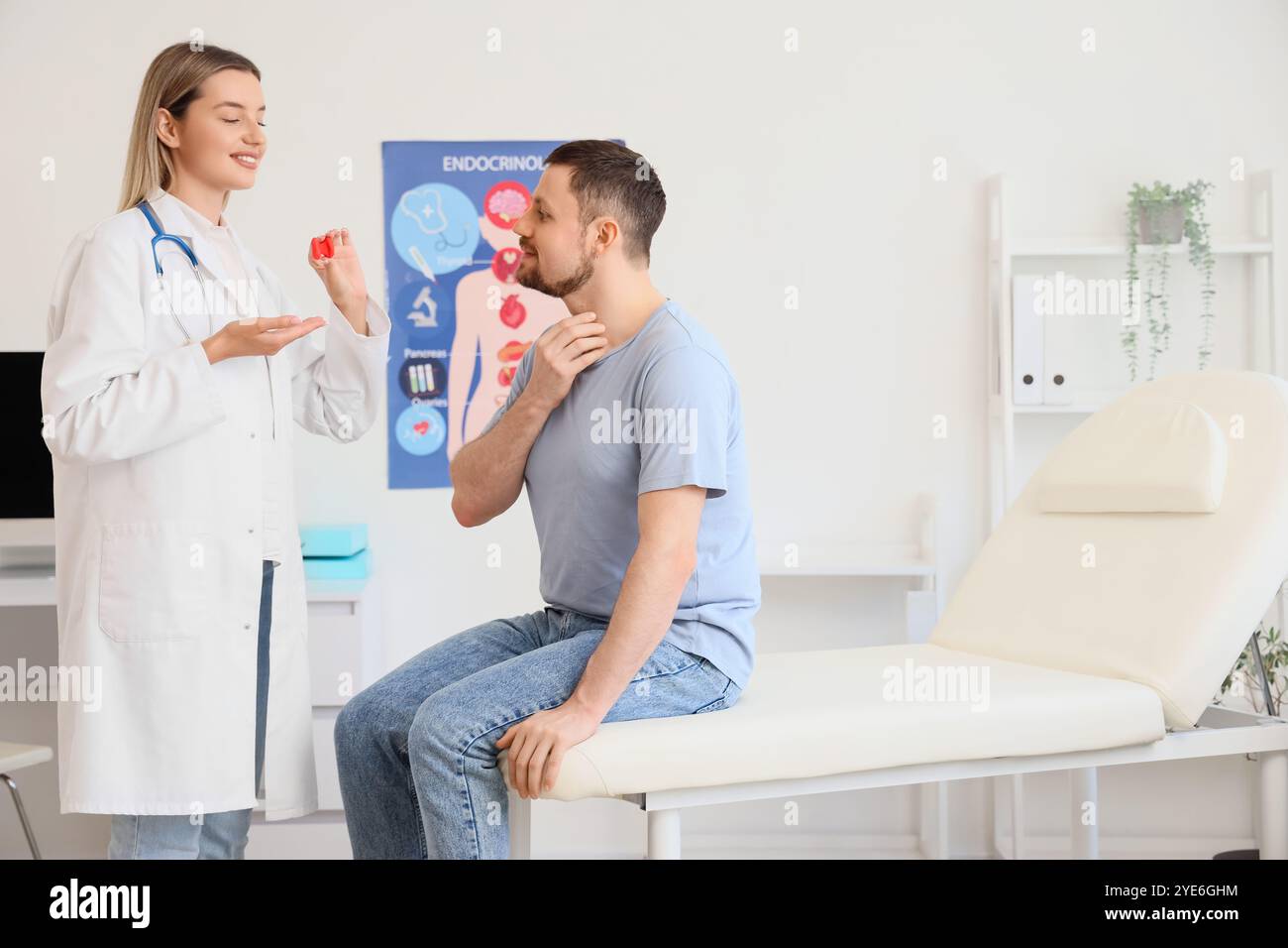 Female endocrinologist showing thyroid gland model to man in clinic ...