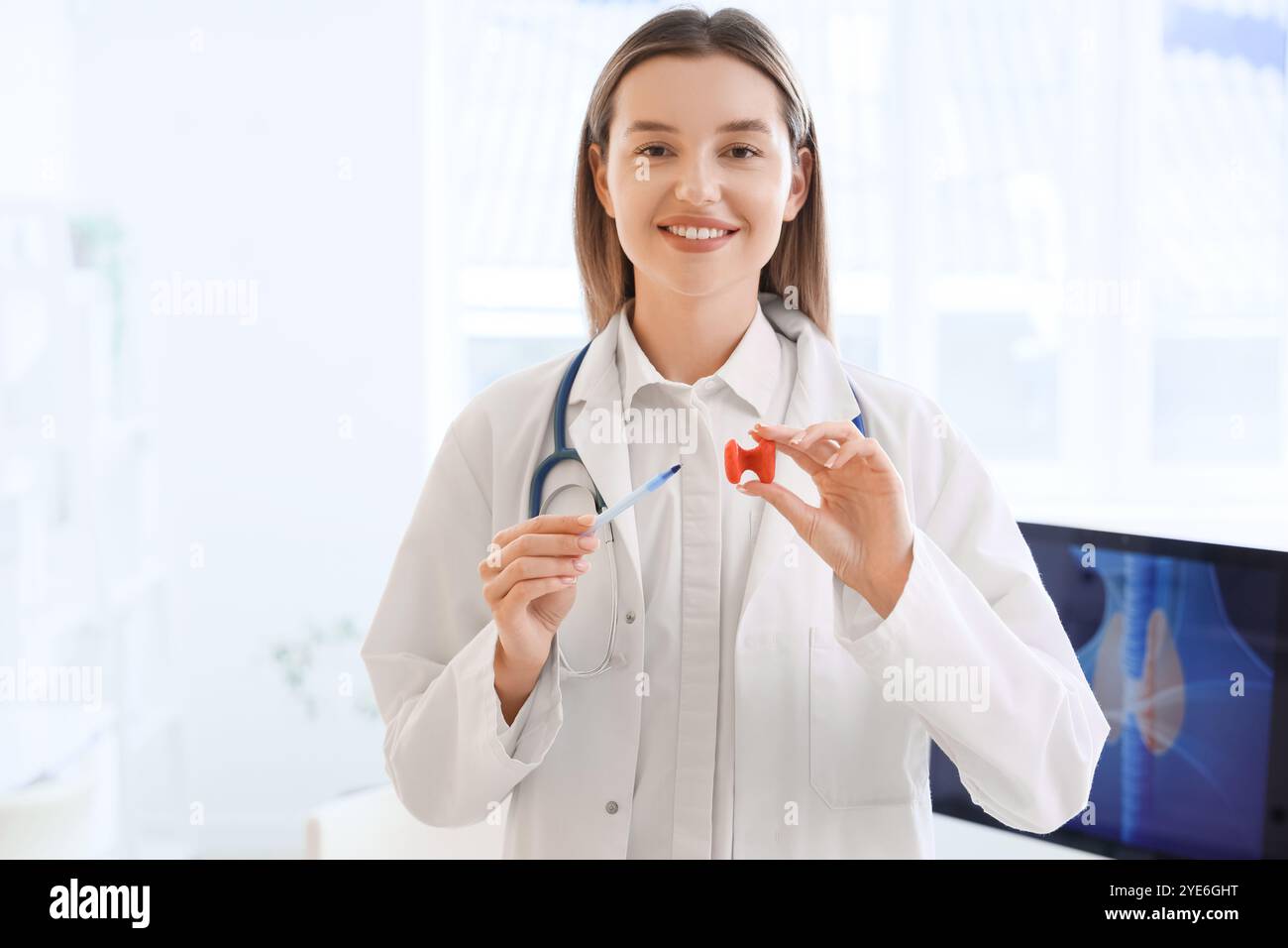 Female endocrinologist with thyroid gland model and pen in clinic Stock ...