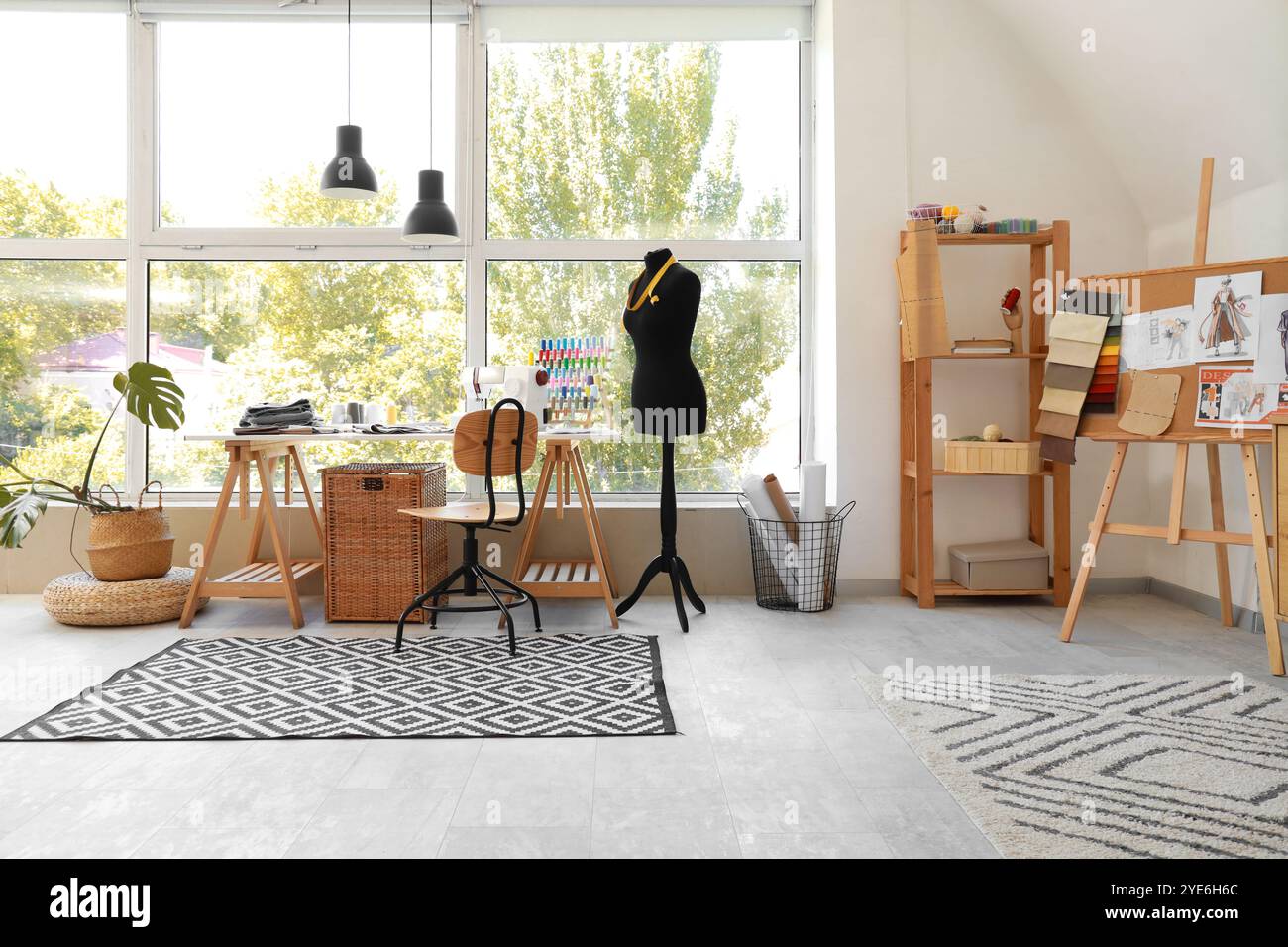 Interior of fashion designer's studio with workplace, shelf unit and ...