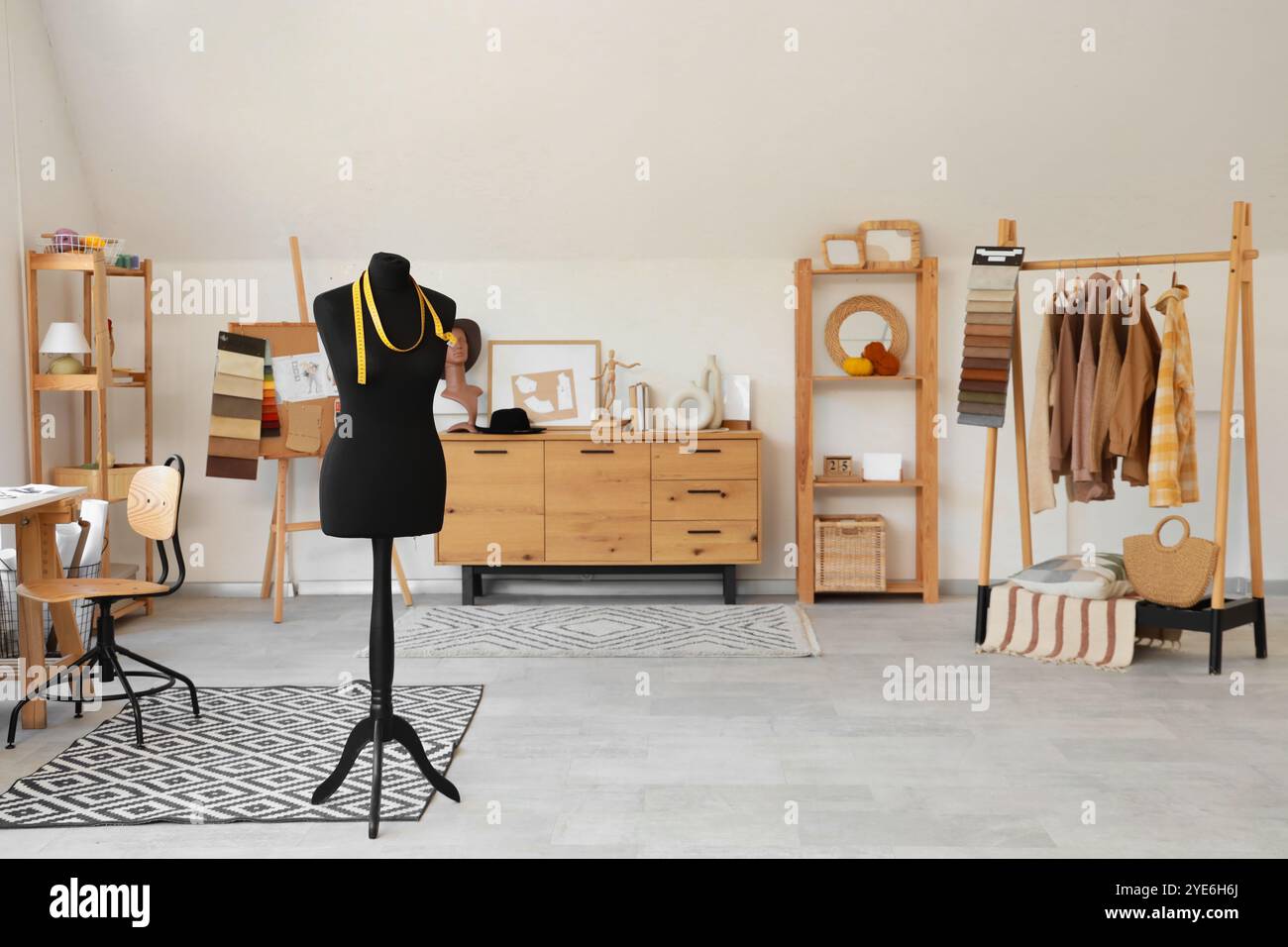 Interior of fashion designer's studio with mannequin, clothes rack and ...