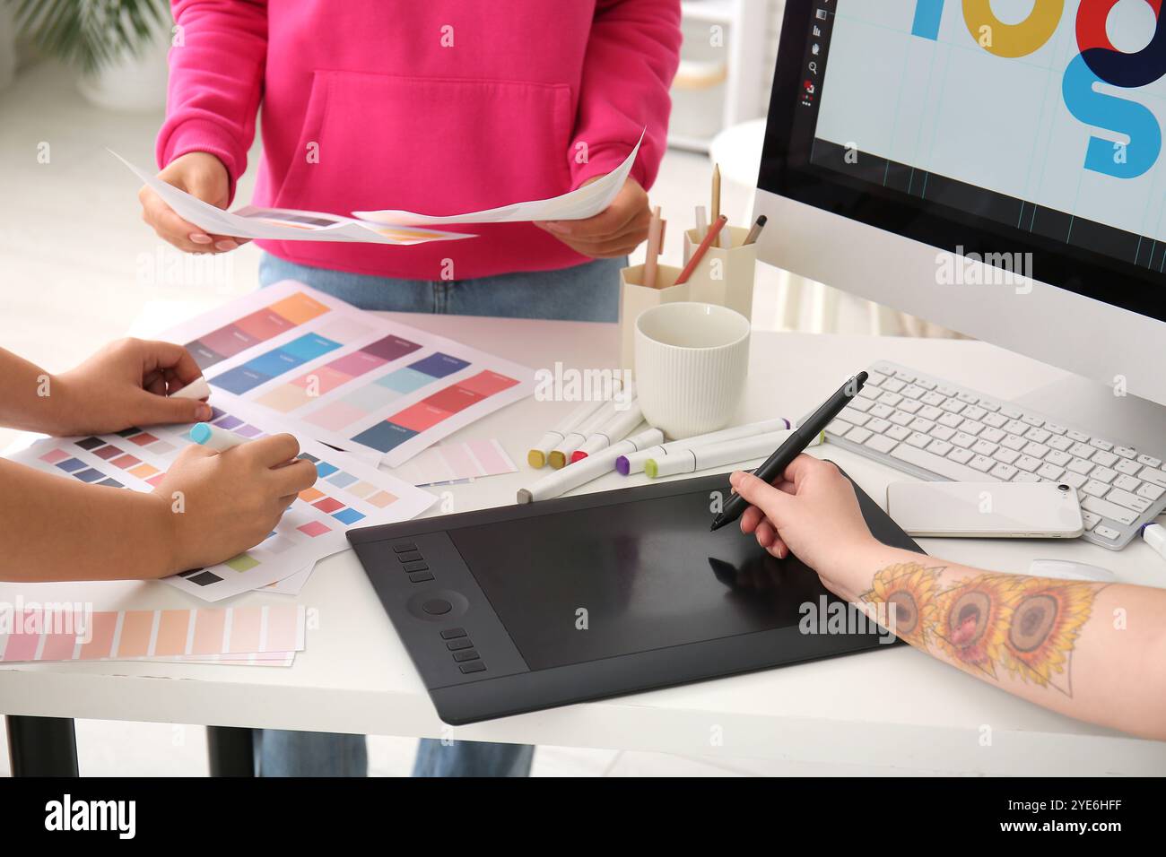 Female graphic designers working with tablet and color palettes at ...
