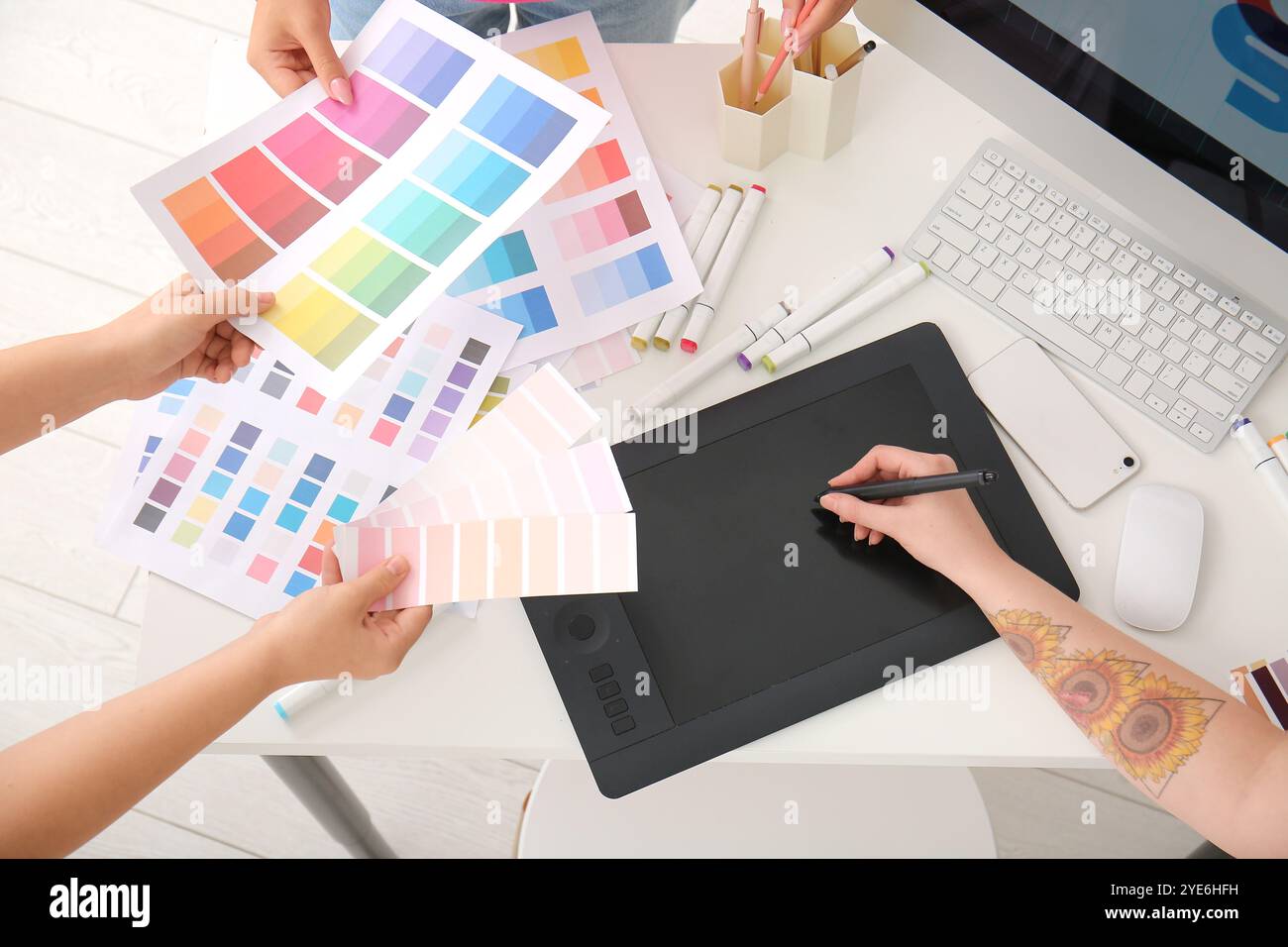 Female graphic designers working with tablet and color palettes at ...