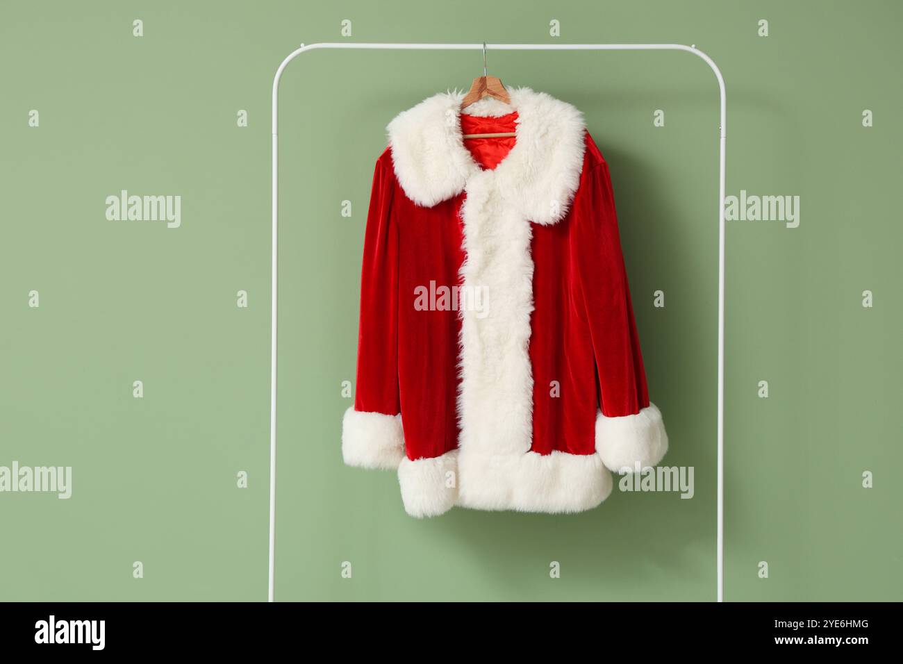 Santa Claus suit hanging on rack near green wall in room Stock Photo ...