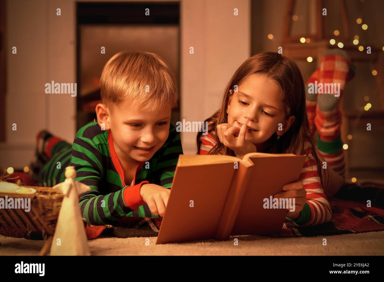 Little children reading Christmas story on floor at home Stock Photo ...