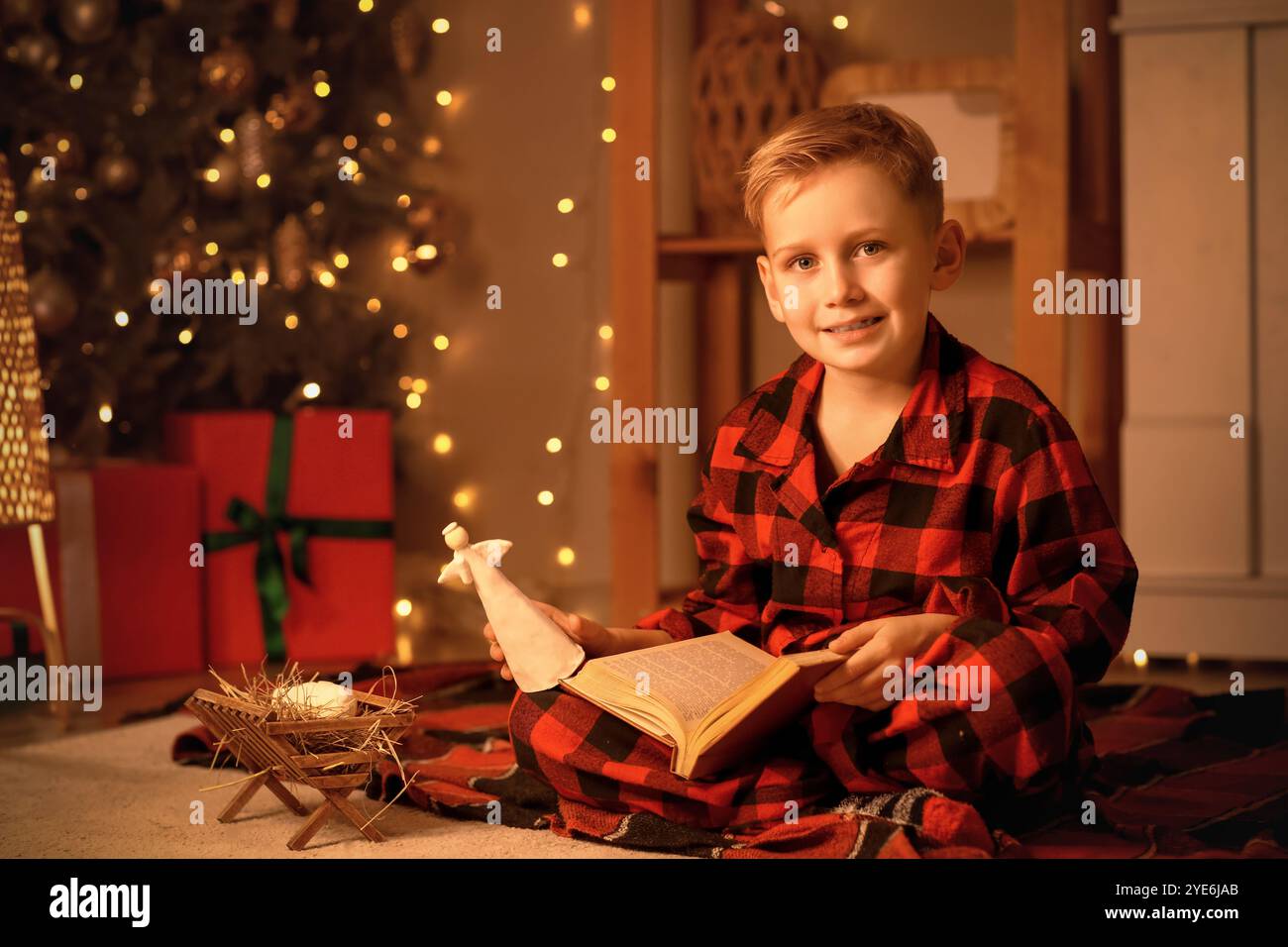 Little boy reading Christmas story at home in evening Stock Photo - Alamy