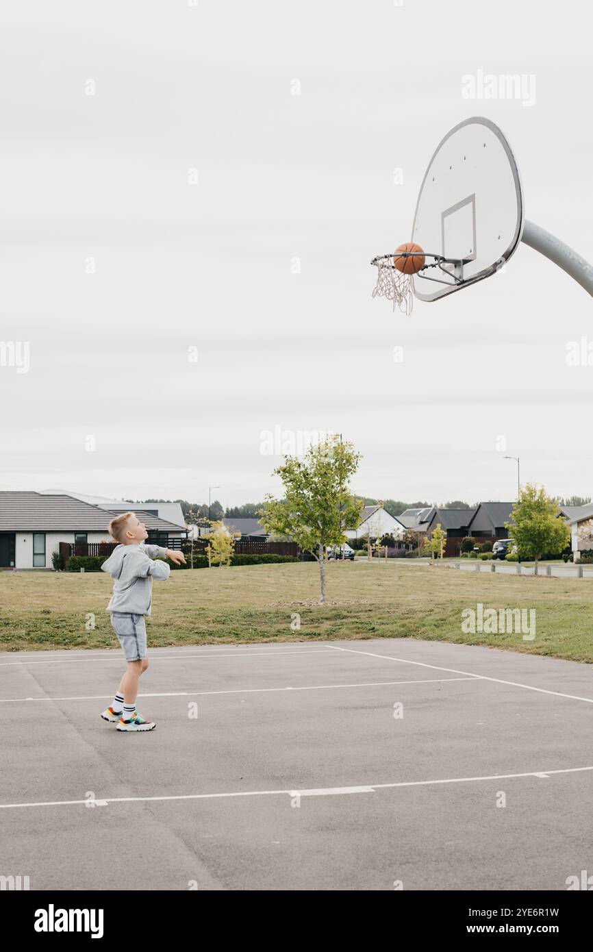 Teenage boy hits goal playing basketball on village sports ground Stock ...