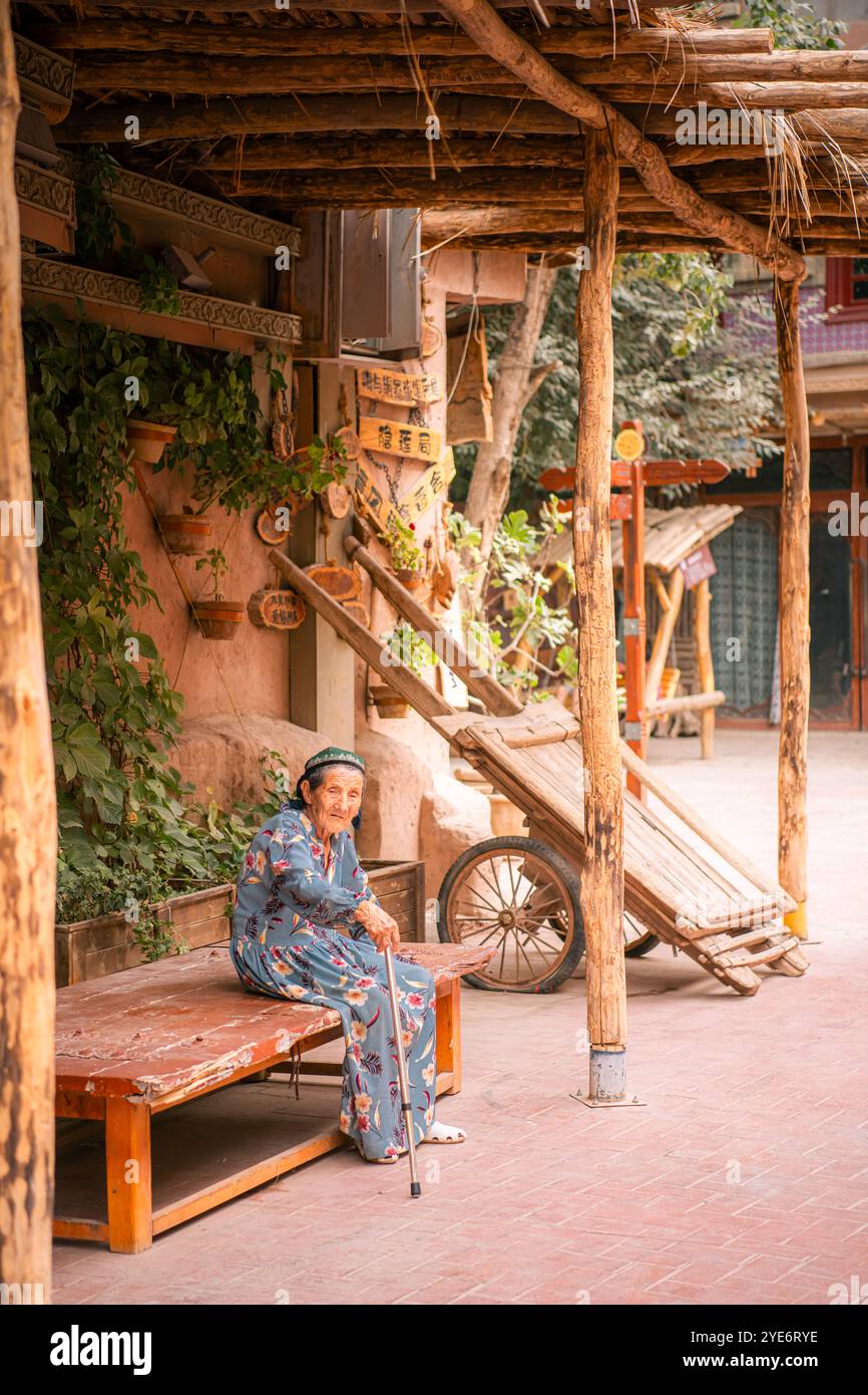 Kashgar, Xinjiang, China - JULY, 17, 2023: The old lady sitting on a ...