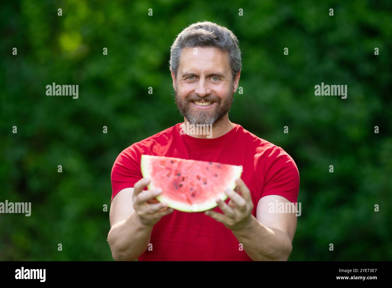 Funny Male face with watermelon, close up. Happy man eating watermelon ...