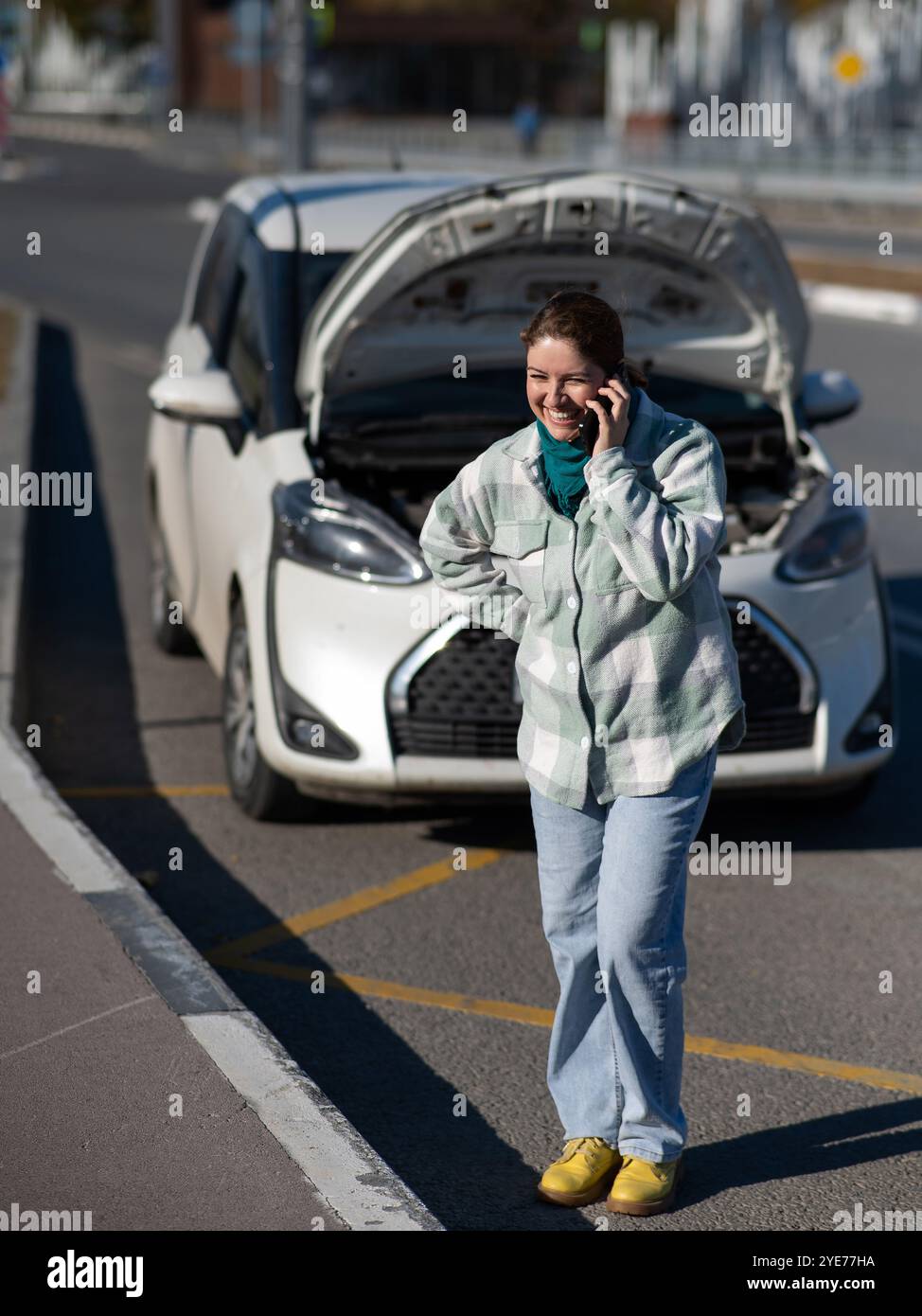 Caucasian woman laughing and calling on phone asking for help standing ...