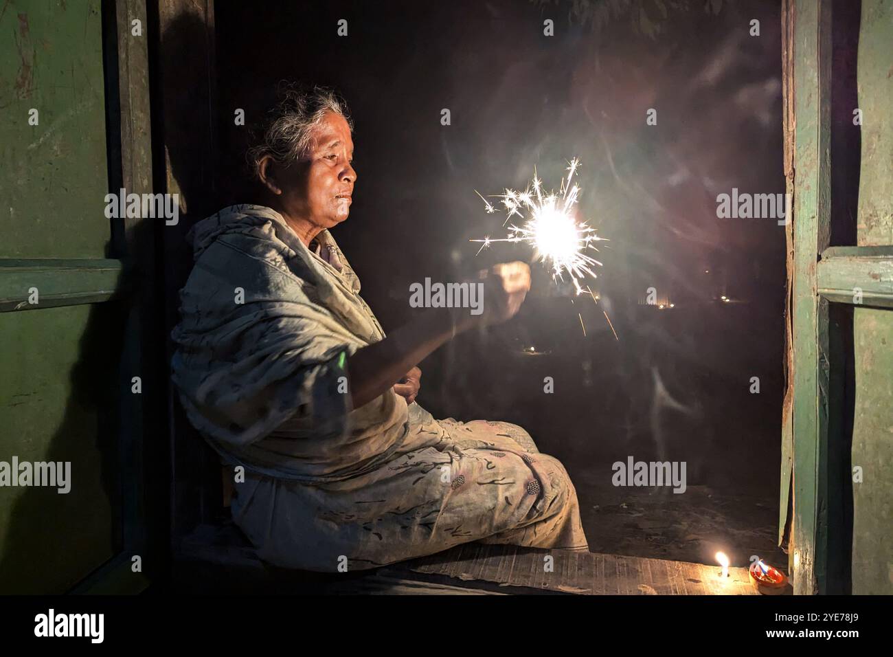 FENI, BANGLADESH - OCTOBER 17: A Hindu old woman playing with light ...
