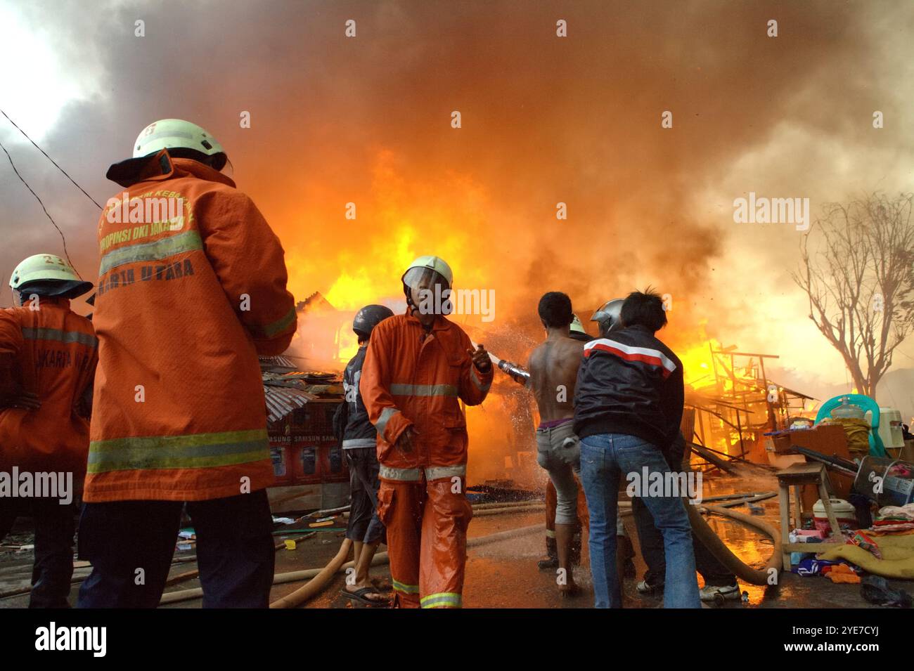 Members of fire brigade and residents fighting a fire accident in a ...