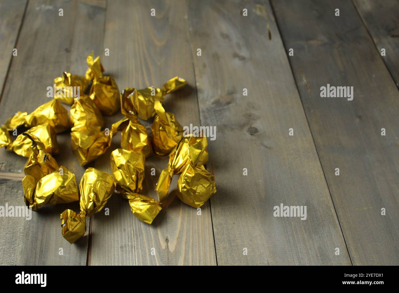 chocolates in golden candy wrappers packaging on a gray background with ...