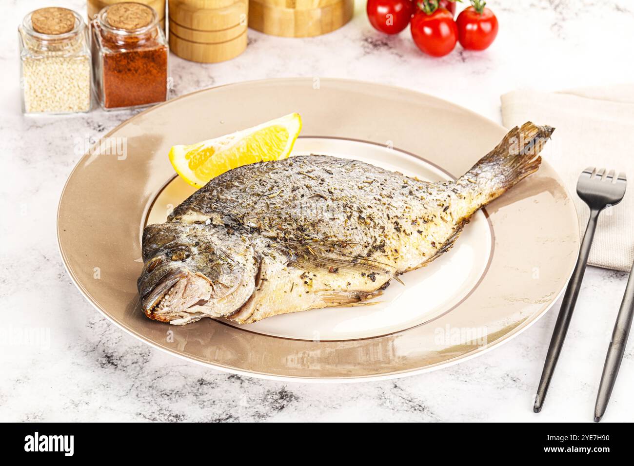 Baked Dorado fish served lemon slice Stock Photo - Alamy