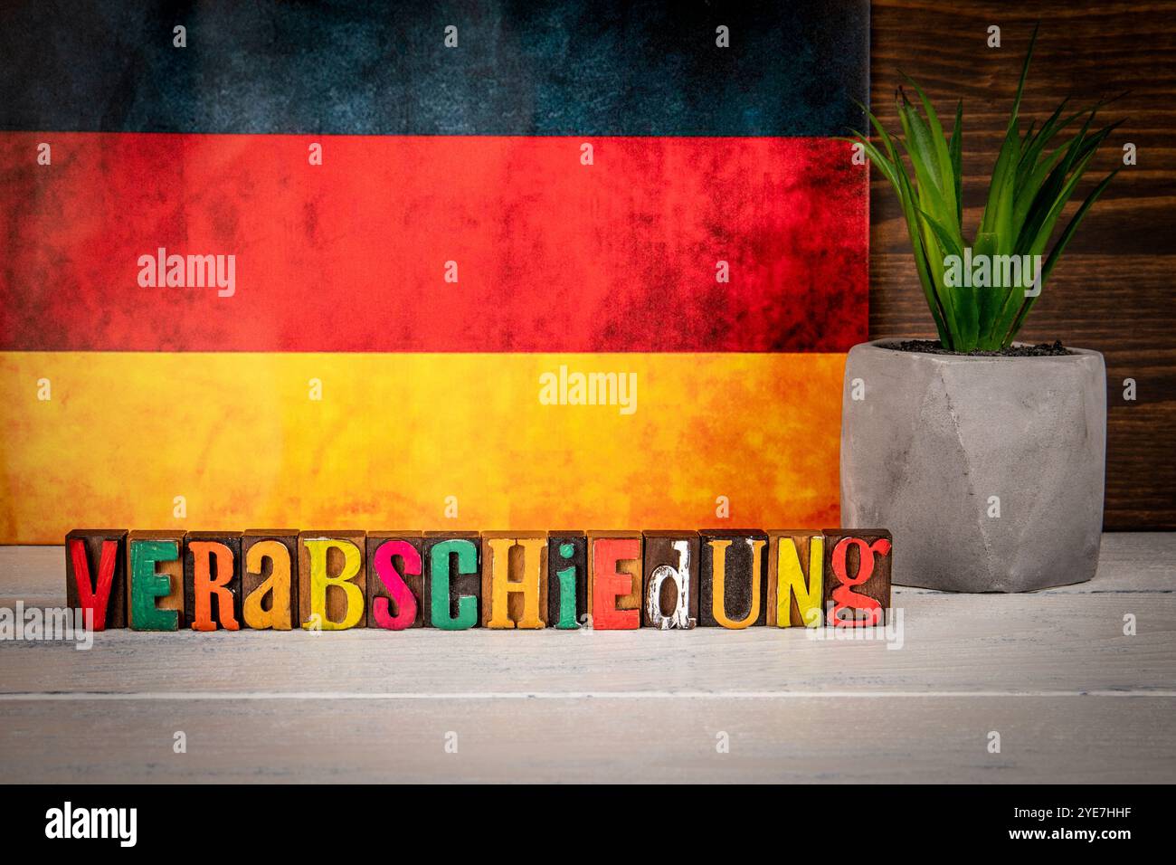 ADOPTION. Text in German. Alphabet blocks on a white painted wooden ...