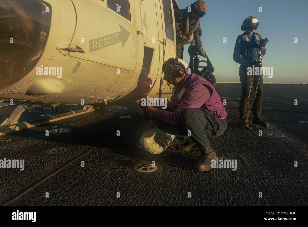 A U.S. Navy aviation boatswain’s mate (fuels), chains a U.S. Marine ...