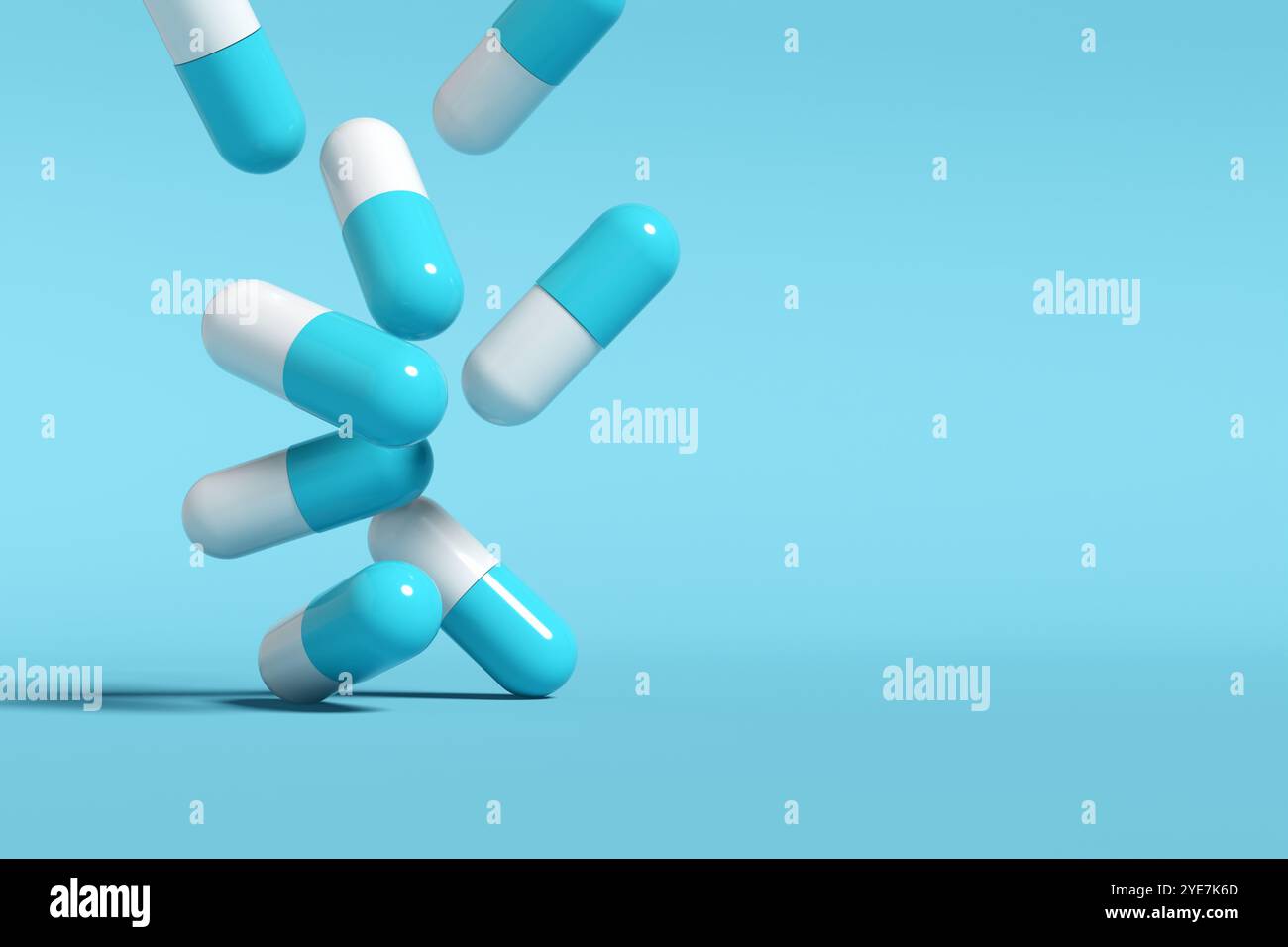 Medicine capsules falling on light blue background representing ...