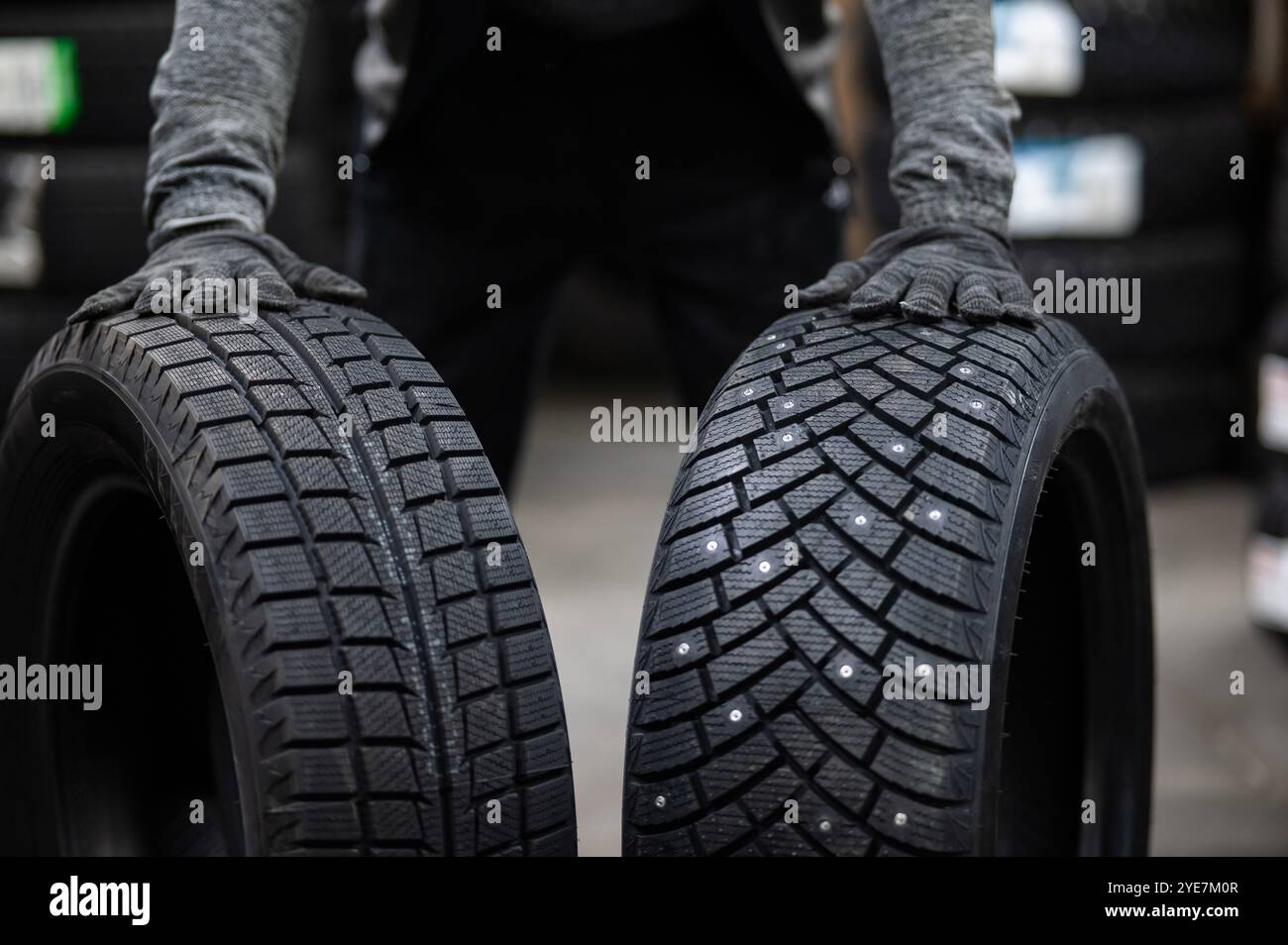 Mechanic keeps new summer and winter car tires in the garage. Comparison of wheels for different ...