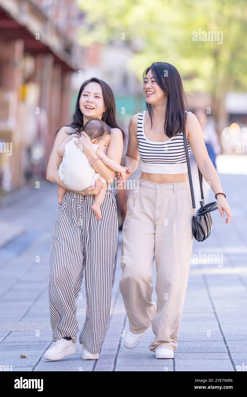 Two Taiwanese women in their 30s wearing casual outfits walk along ...