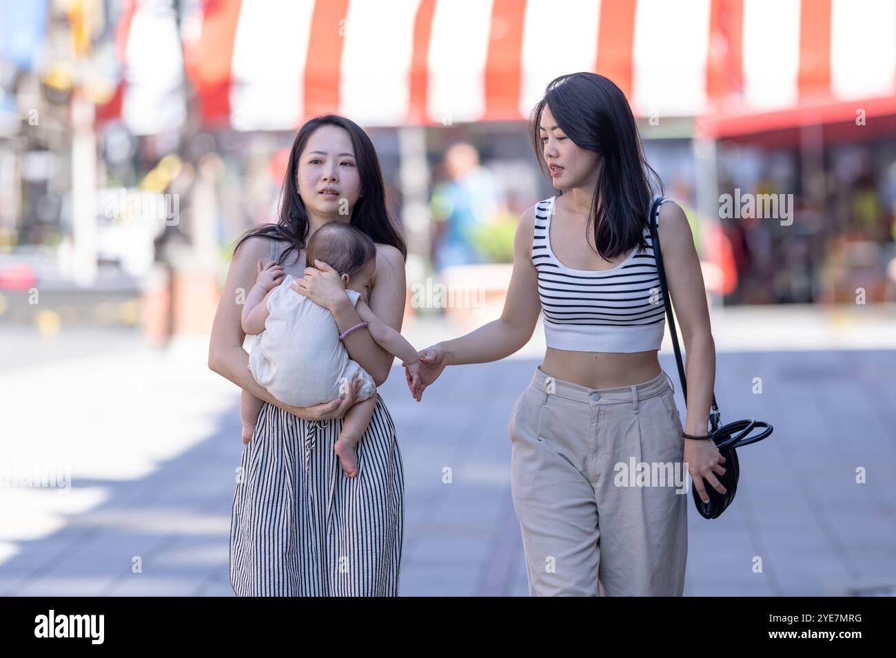 Two Taiwanese women in their 30s wearing casual outfits walk along ...