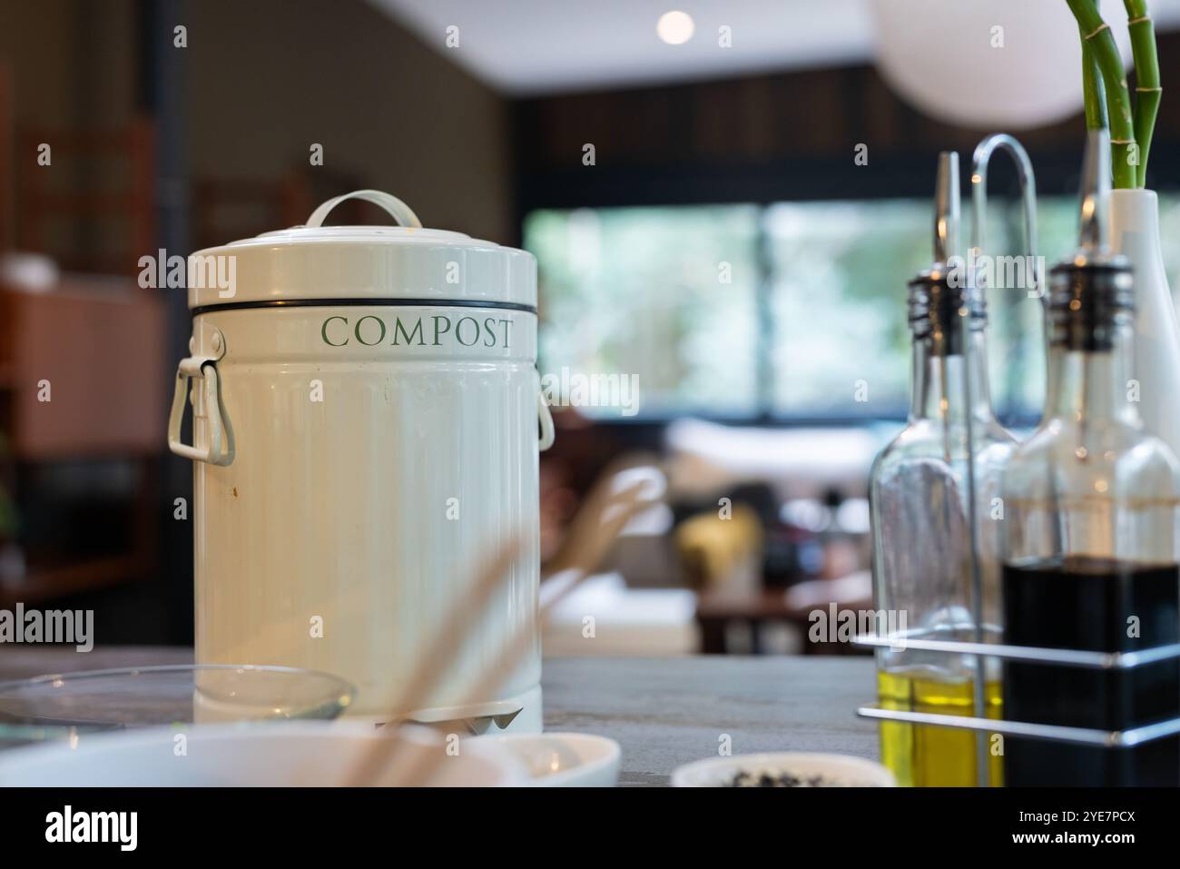 Compost bin on kitchen counter with olive oil bottles in modern home ...