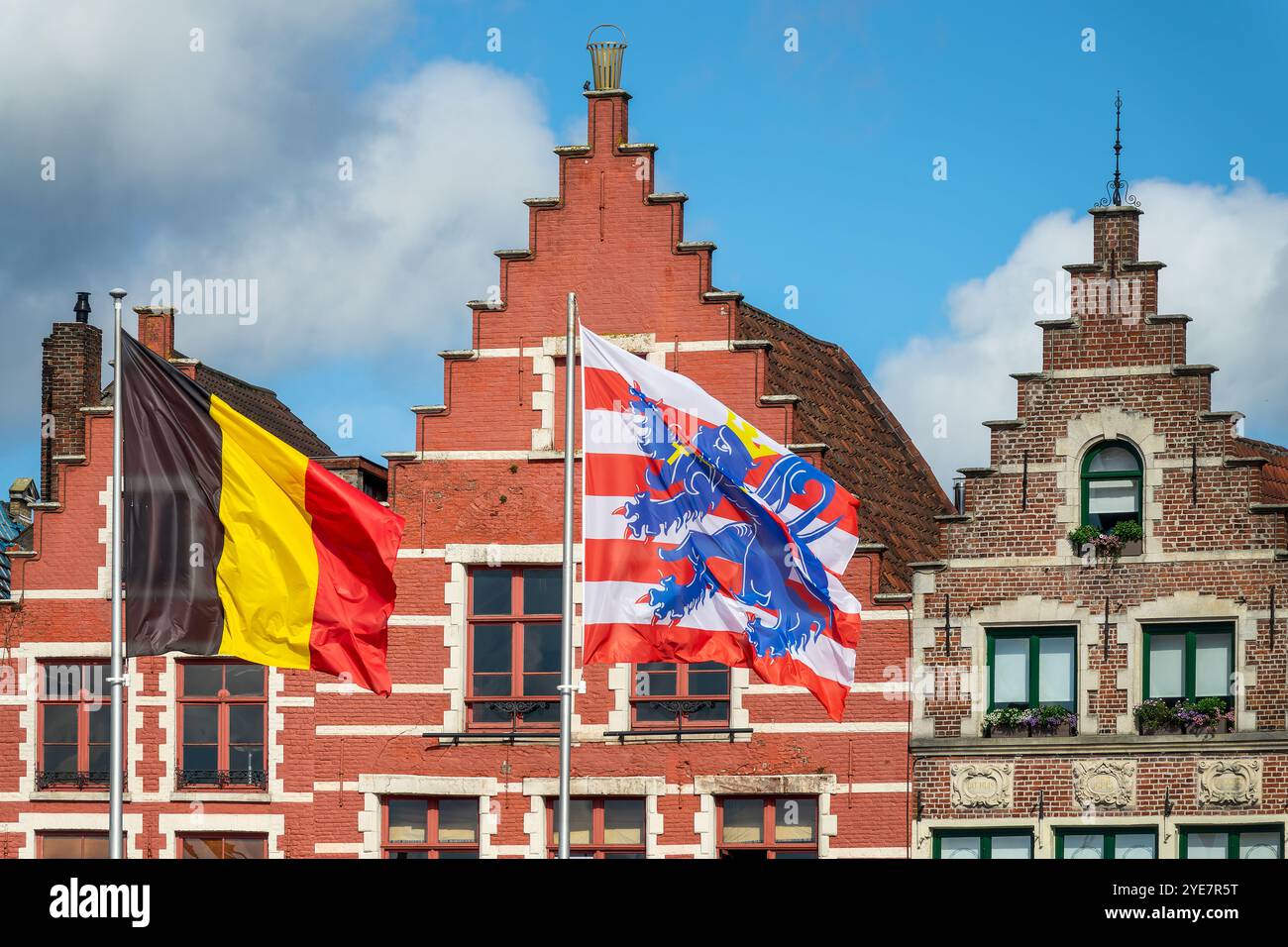 Flags of Belgium and of the city of Bruges with colorful houses on ...