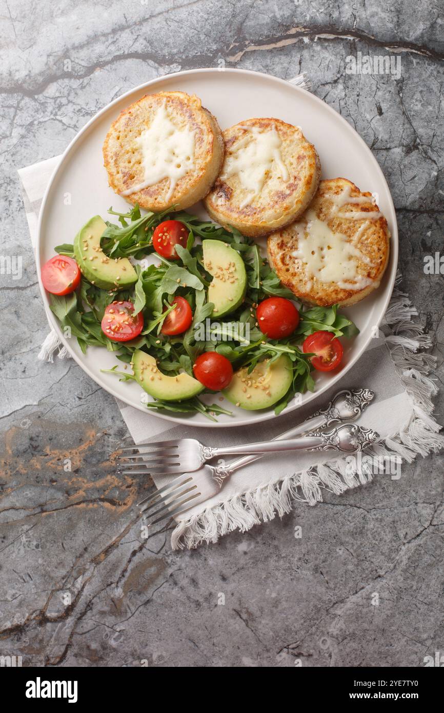 Breakfast Eggy Crumpets with vegetables salad closeup on the plate on ...