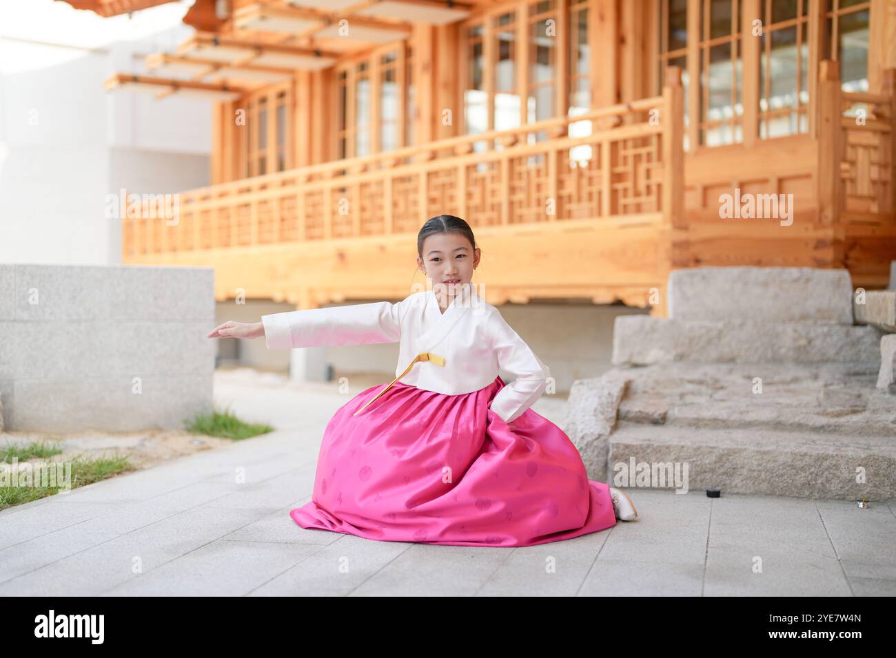 A 9-year-old Korean girl wearing a hanbok is performing a traditional ...