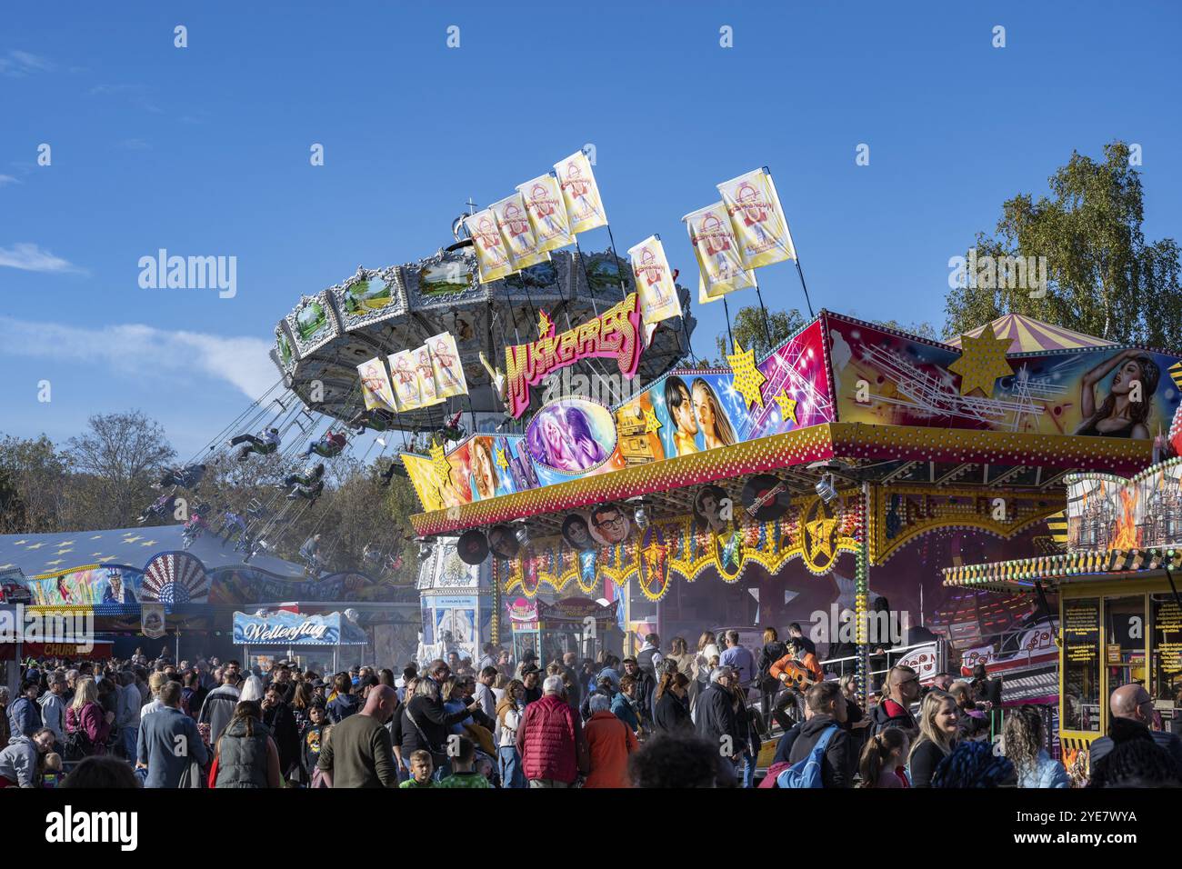 Crowd of people on fairground, amusement park, amusement ride ...