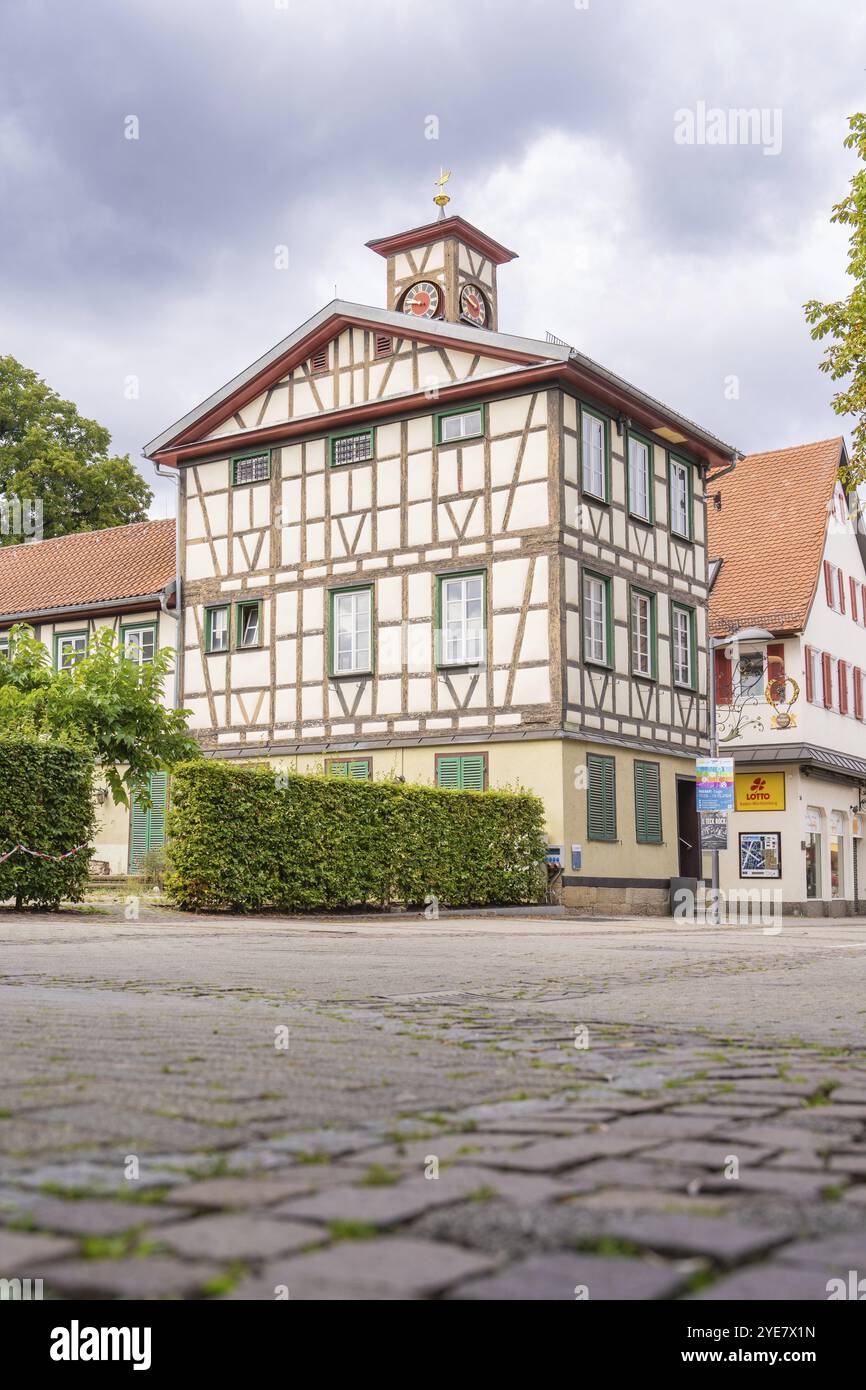 A historic half-timbered house with a small tower under a cloudy sky ...